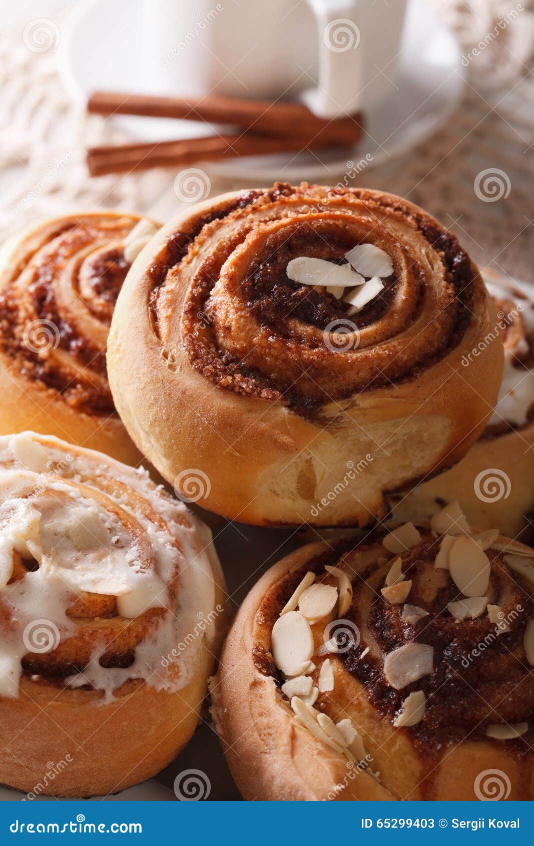 Freshly Baked Cinnamon Rolls with Icing and Almonds Macro. Vertical ...