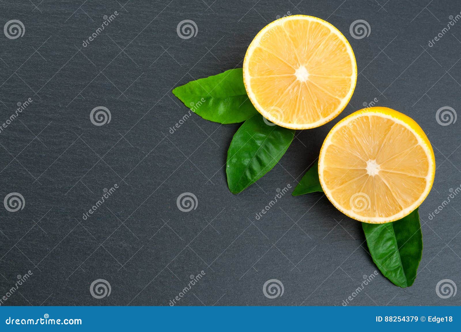 Freshly Cut Half Lemons with Leaves on Black Stone. Copy Space Stock ...