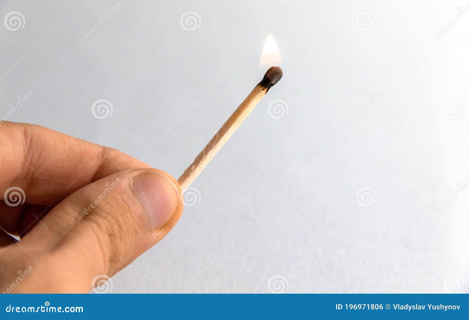 Freshly Lit Match in the Hand of a Teenager on a Plain White Background ...