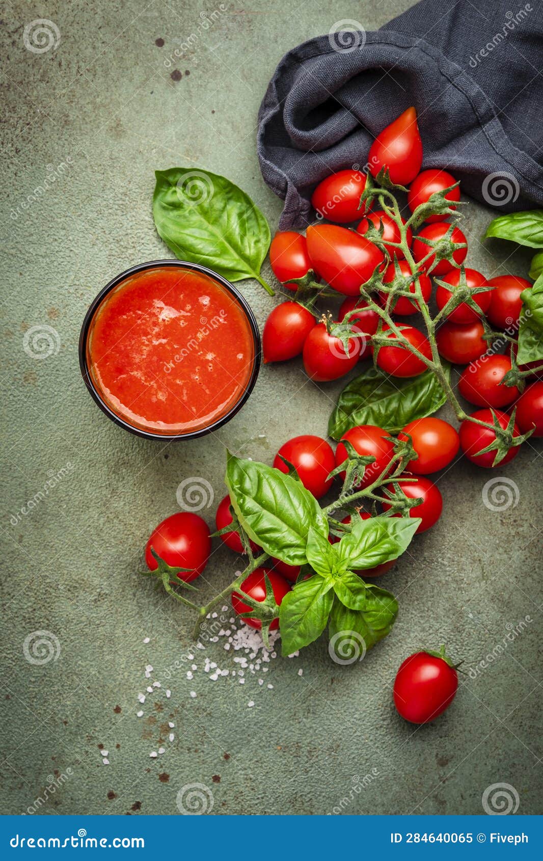 Freshly Squeezed Tomato Juice With Sea Salt In Glass And Red Cherry Tomatoes On Branches With