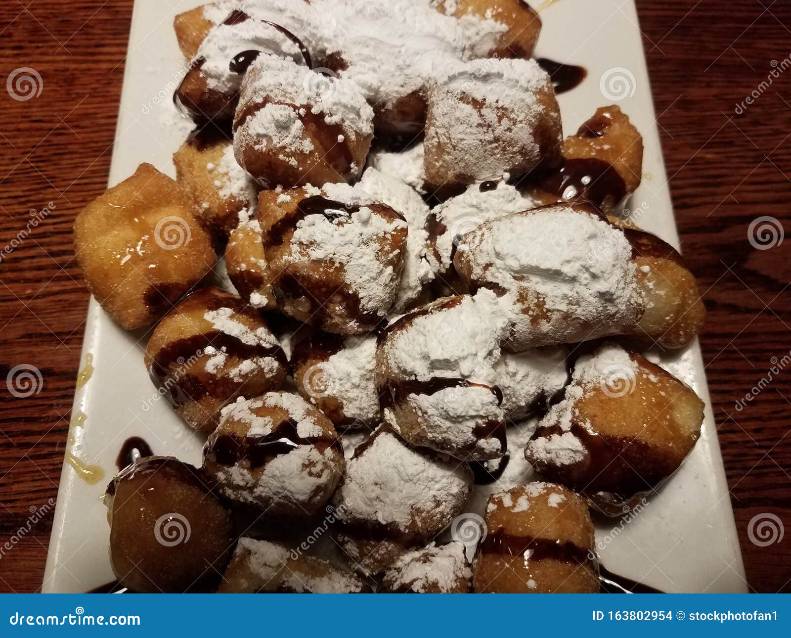 Fried Dough with Powdered Sugar and Chocolate Syrup Stock Photo - Image ...