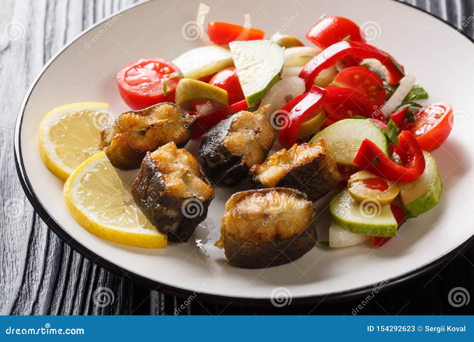 Fried European Eel with Fresh Vegetable Salad Closeup on a Plate ...