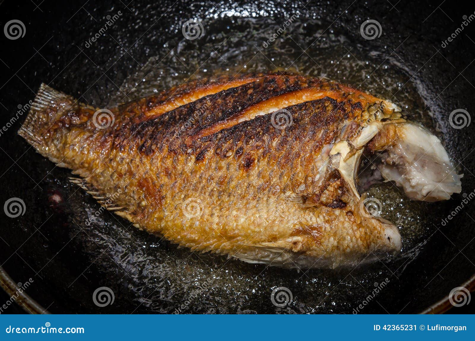 Fried fish in a frying pan stock image. Image of food - 42365231