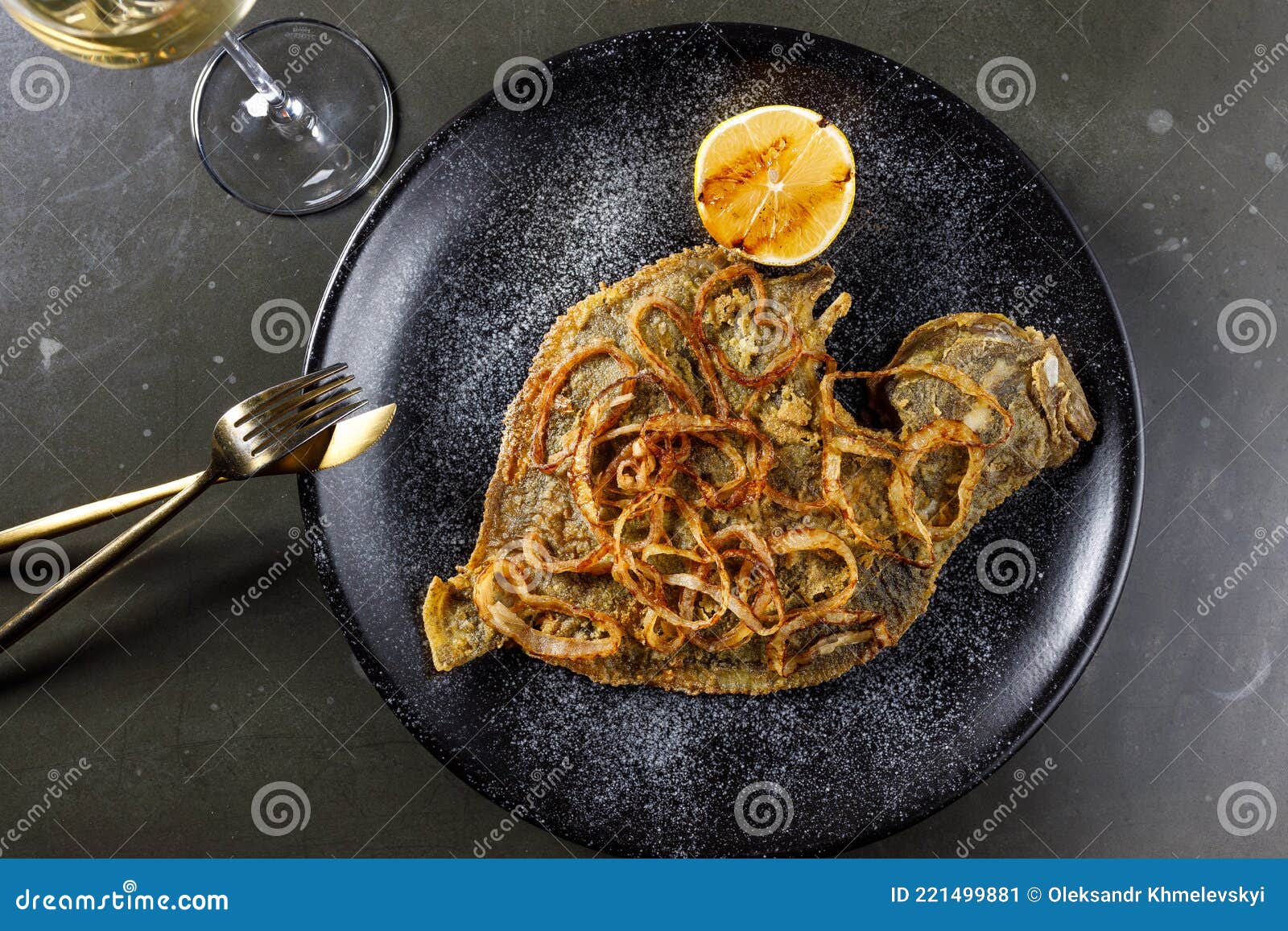 Fried Flounder with Onion and Lemon on a Black Clay Plate Stock Image ...