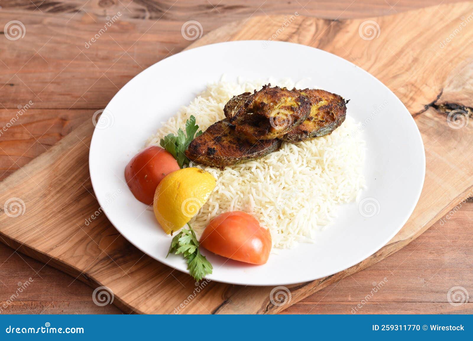 Fried Ilish Fish with Rice and Vegetables on a Wooden Surface Stock ...