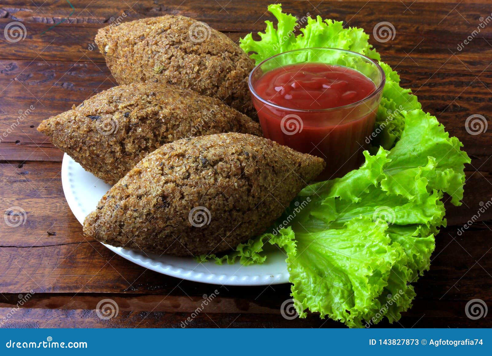 Fried Kibbeh with Tomato Sauce on a Plate, Over Rustic Wooden Table ...