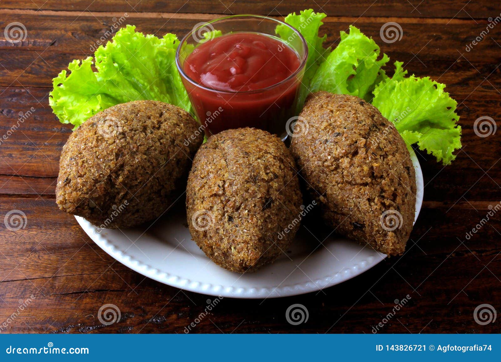Fried Kibbeh with Tomato Sauce on a Plate, Over Rustic Wooden Table ...