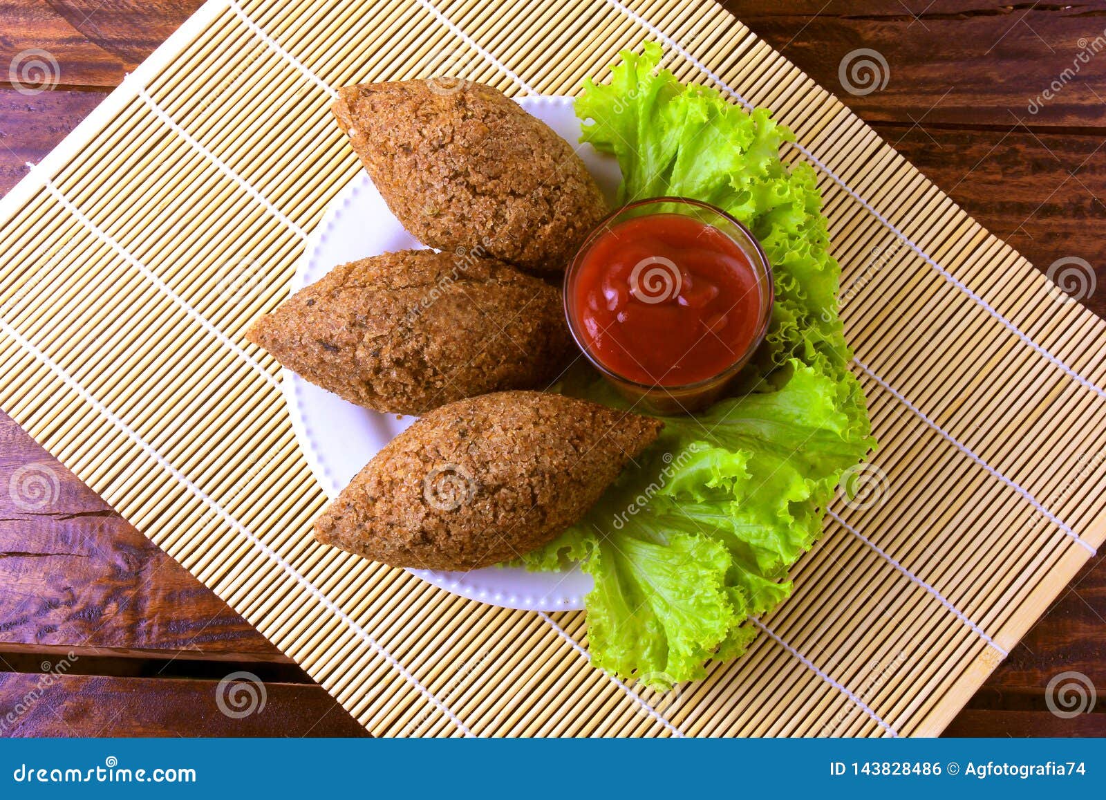 Fried Kibbeh with Tomato Sauce on a Plate, Over Rustic Wooden Table ...