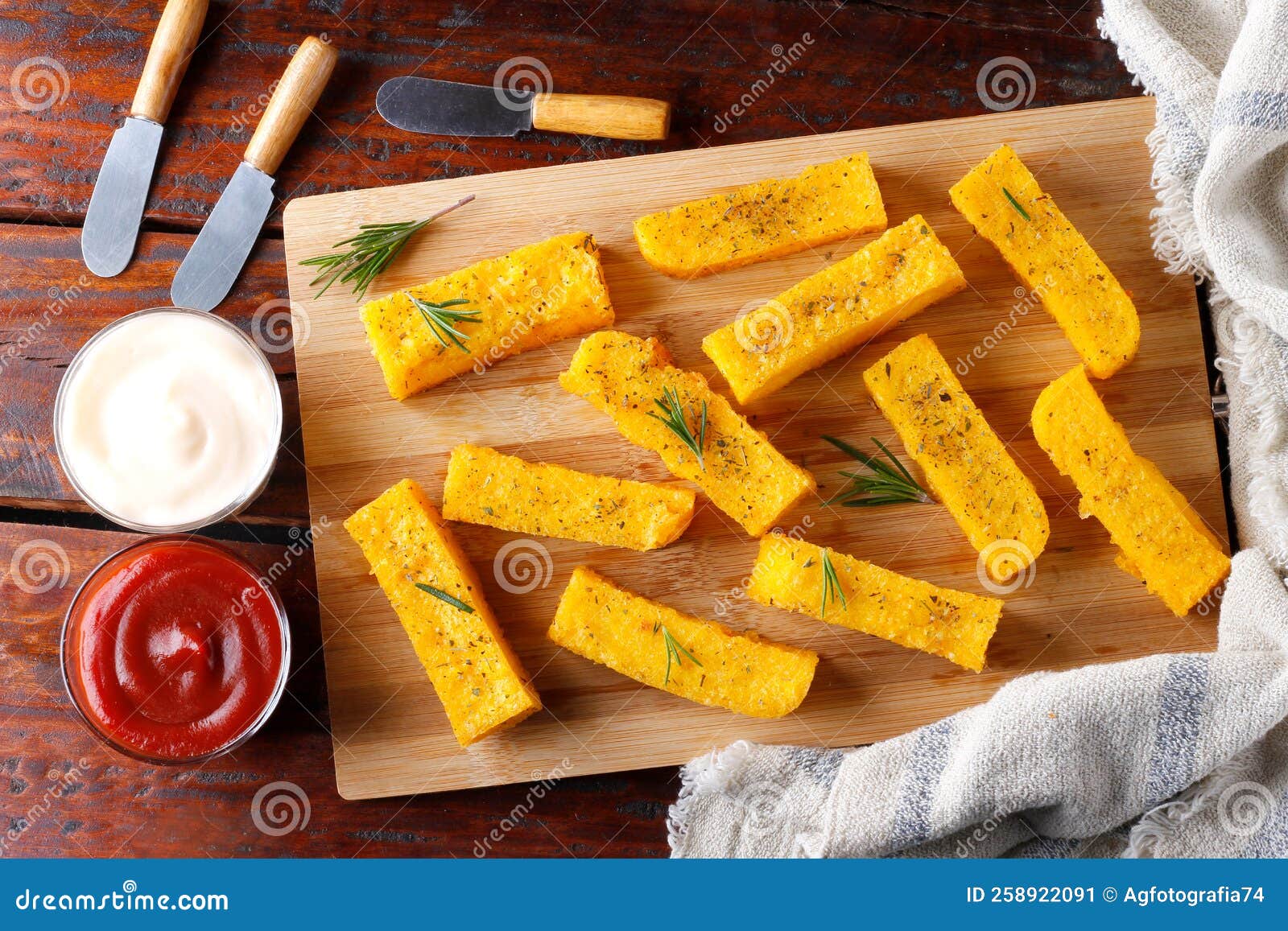 Fried Polenta Sticks on Cutting Board Over Rustic Wooden Table Stock ...