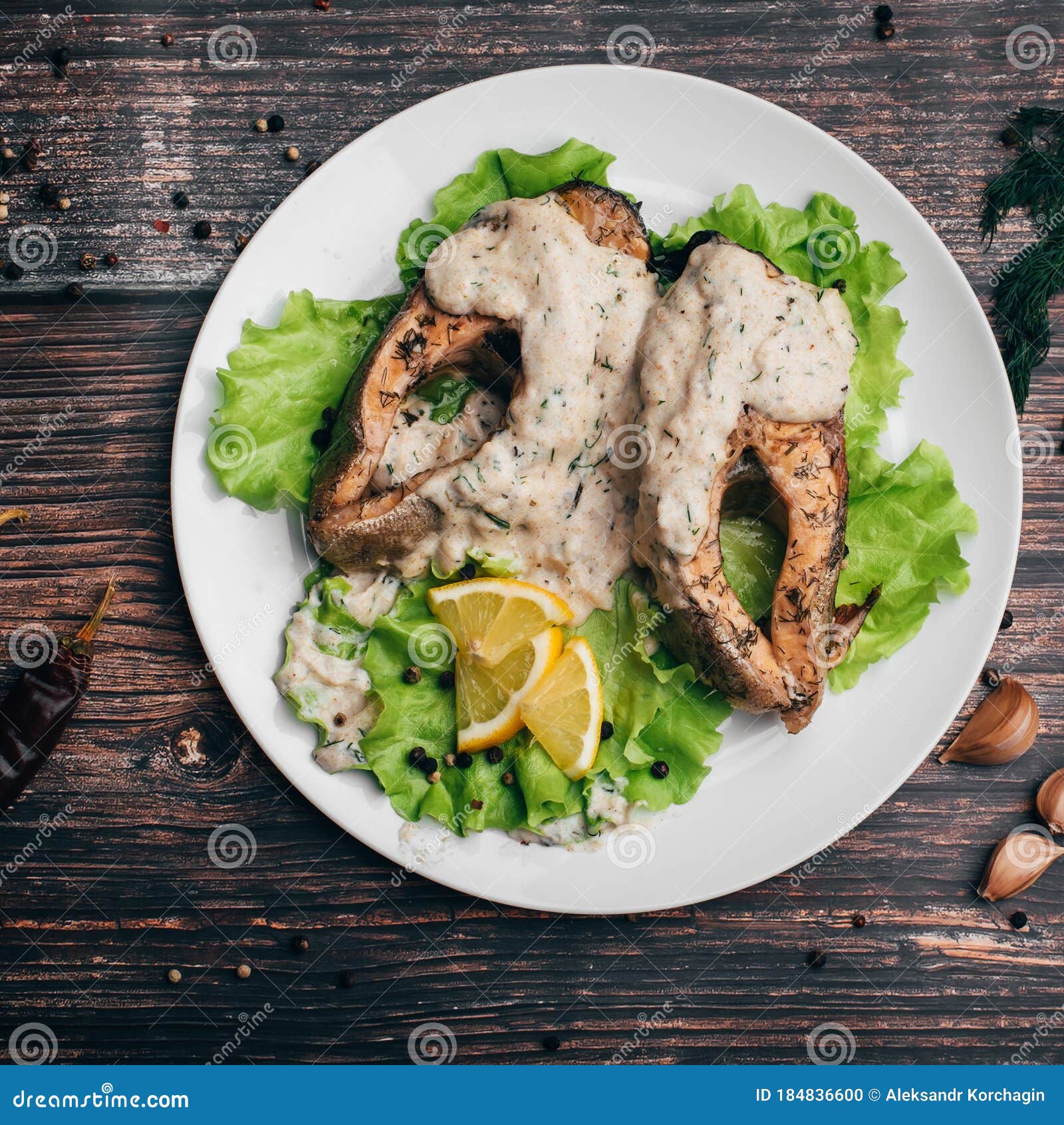 Fried Red Fish in Cream Sauce with Lemon and Lettuce in White Plate ...