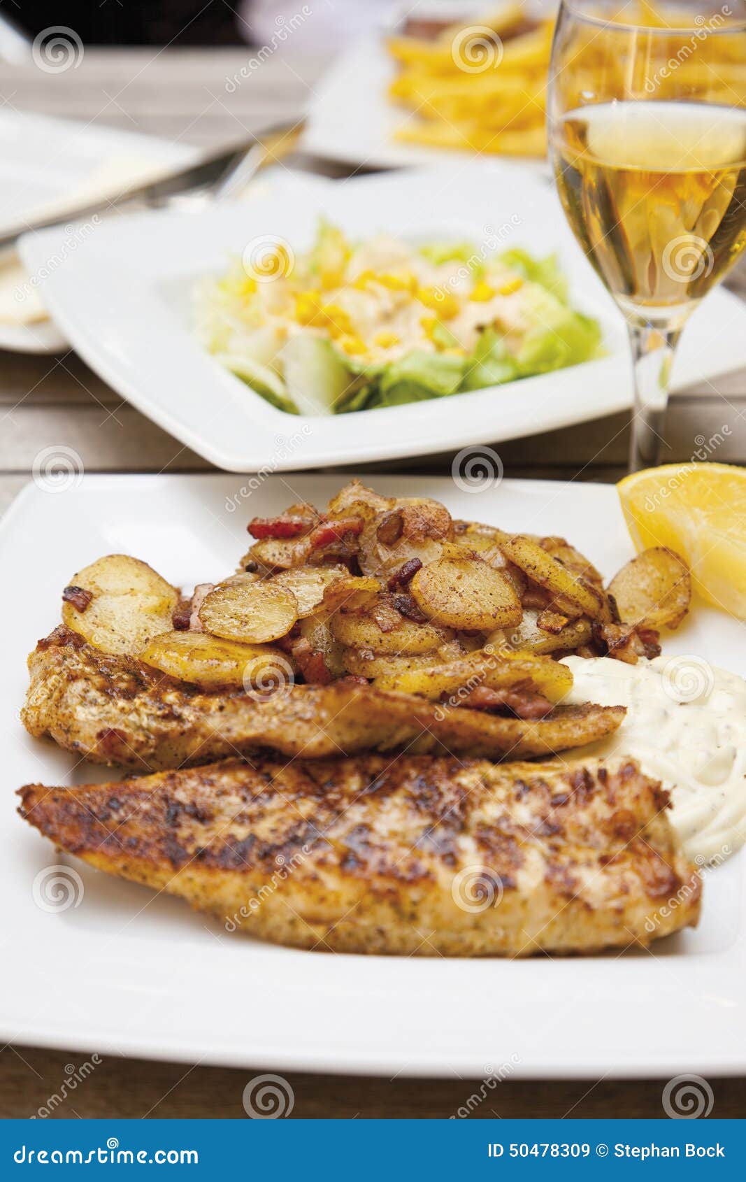 Fried Redfish with Roasted Potatoes and Sauce in Plate with Glass Stock ...