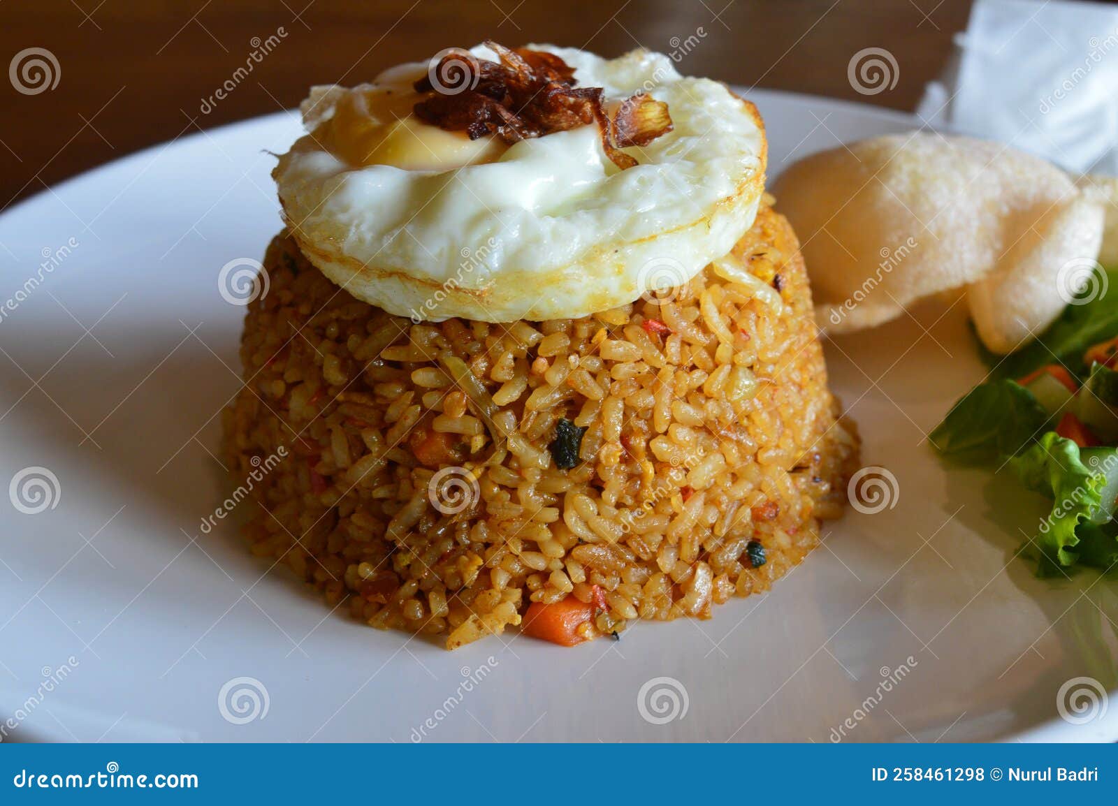 Fried Rice on a White Plate Topped with an Egg, with Pickles and ...