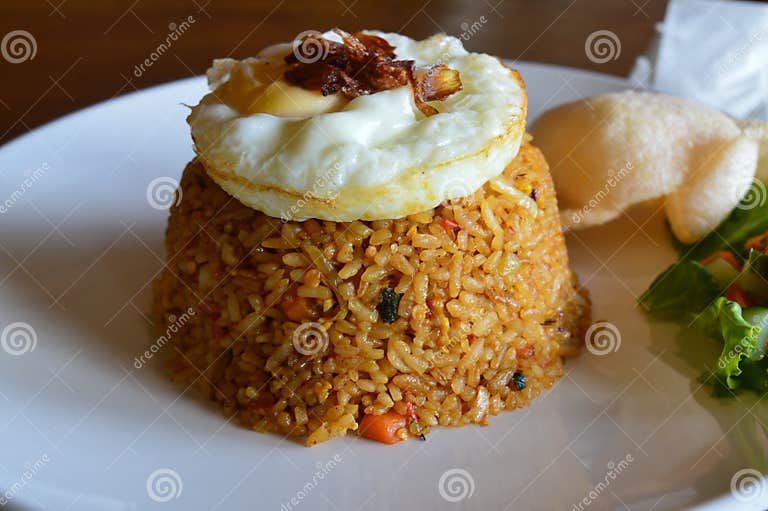 Fried Rice on a White Plate Topped with an Egg, with Pickles and ...
