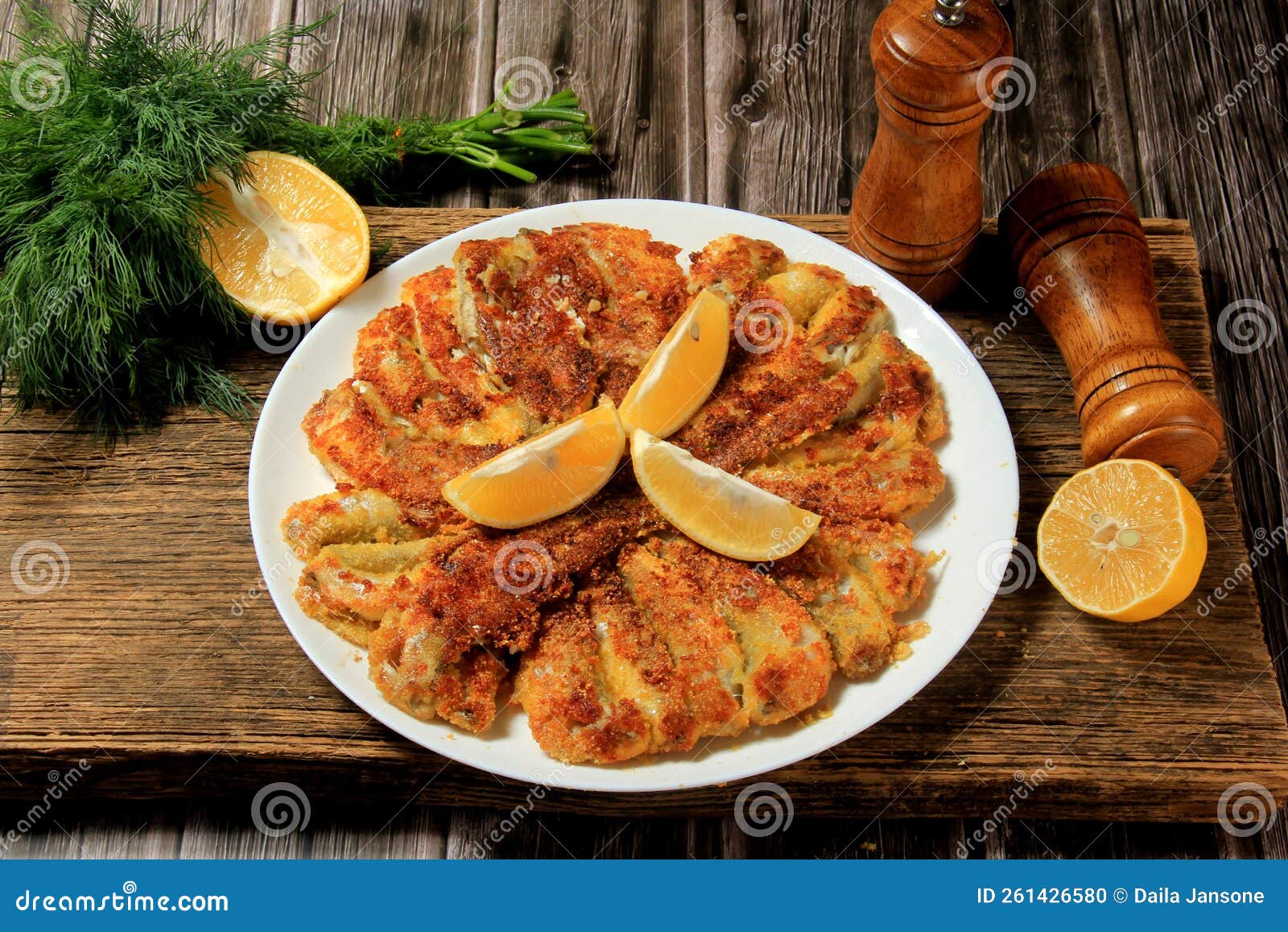 Fried Small Fish on a Plate, Decorated with Lemon Slices Stock Photo ...
