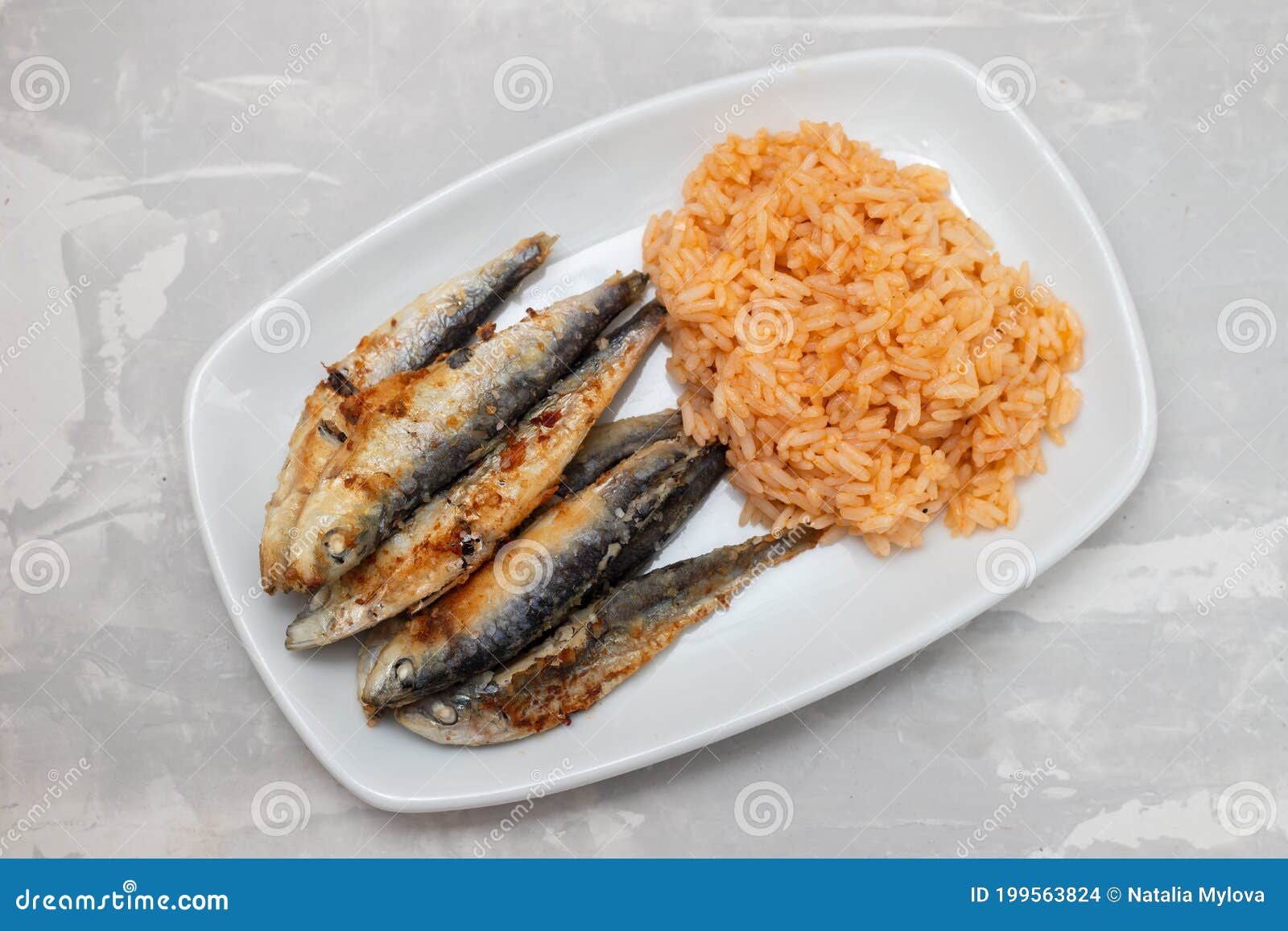 Fried Small Sardines with Tomato Rice on White Dish on Ceramic ...