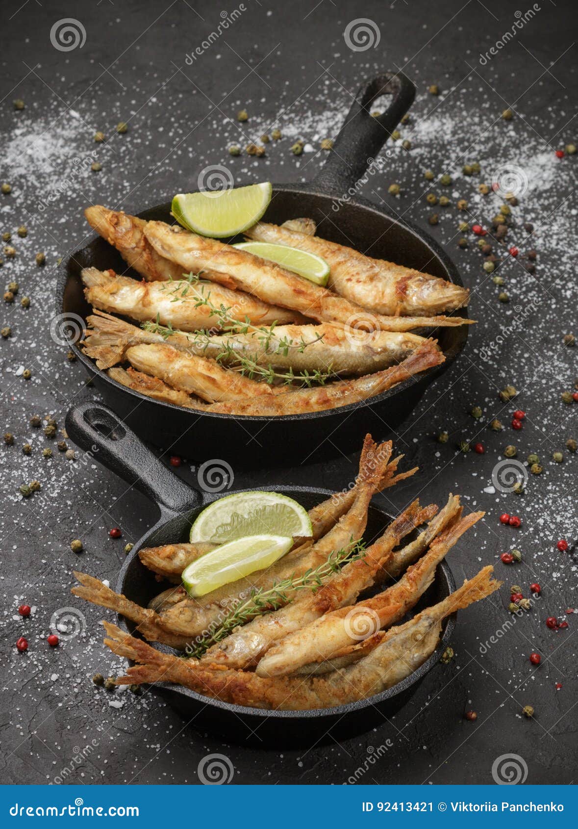 Fried Smelt in a Frying Pan on the Table with Spices, Lime and Thyme ...