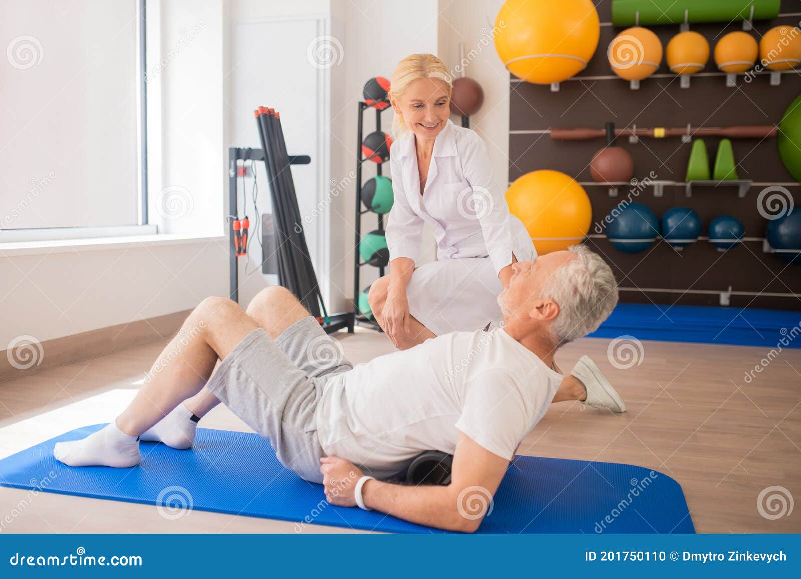 A Female Physical Therapist in Lab Coat Supporting a Patient and ... A Female Physical Therapist in Lab Coat Supporting a Patient and ...