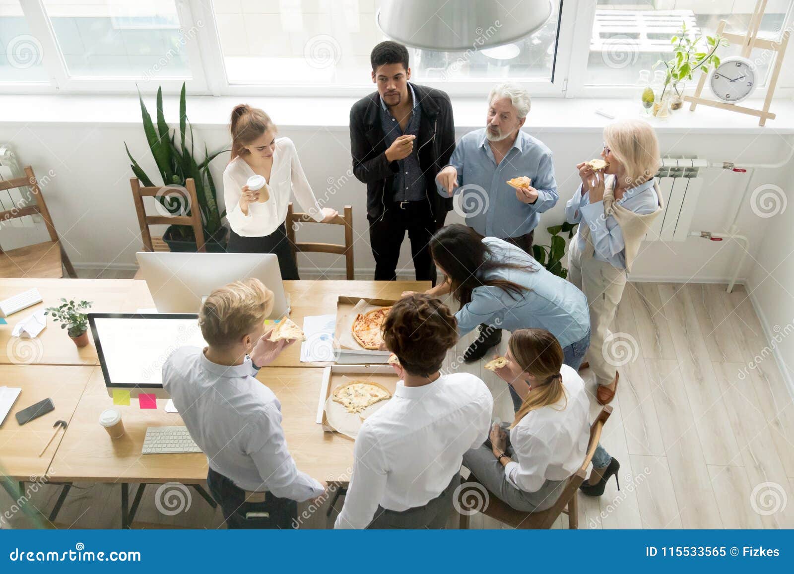 Diverse Business Team Eating Pizza Together In Office Top View Stock