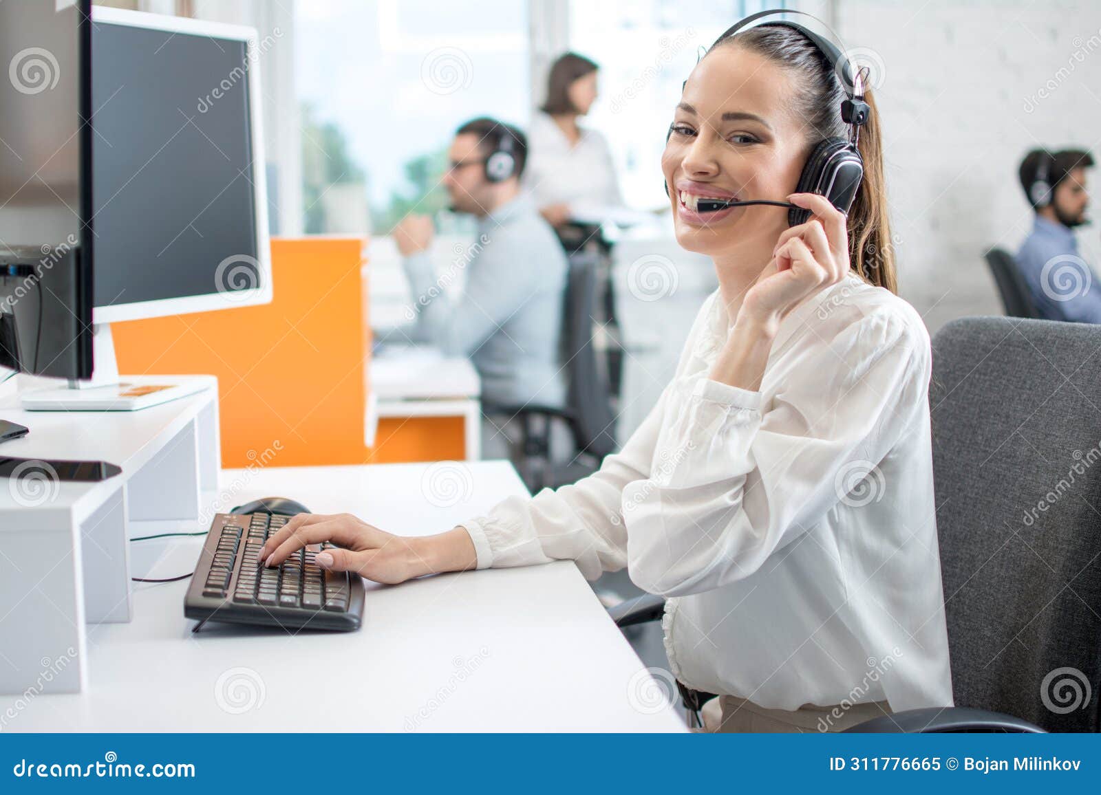 Friendly Call Center Operator Lady in Wireless Headset Talking with ...