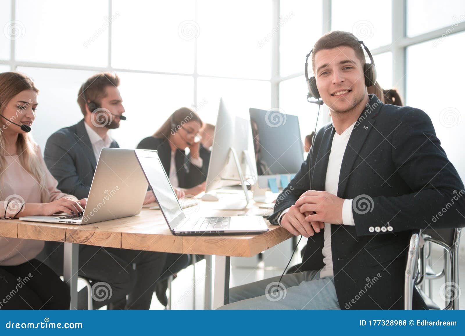 Friendly Call Center Operator Sitting at His Desk. Stock Photo - Image ...