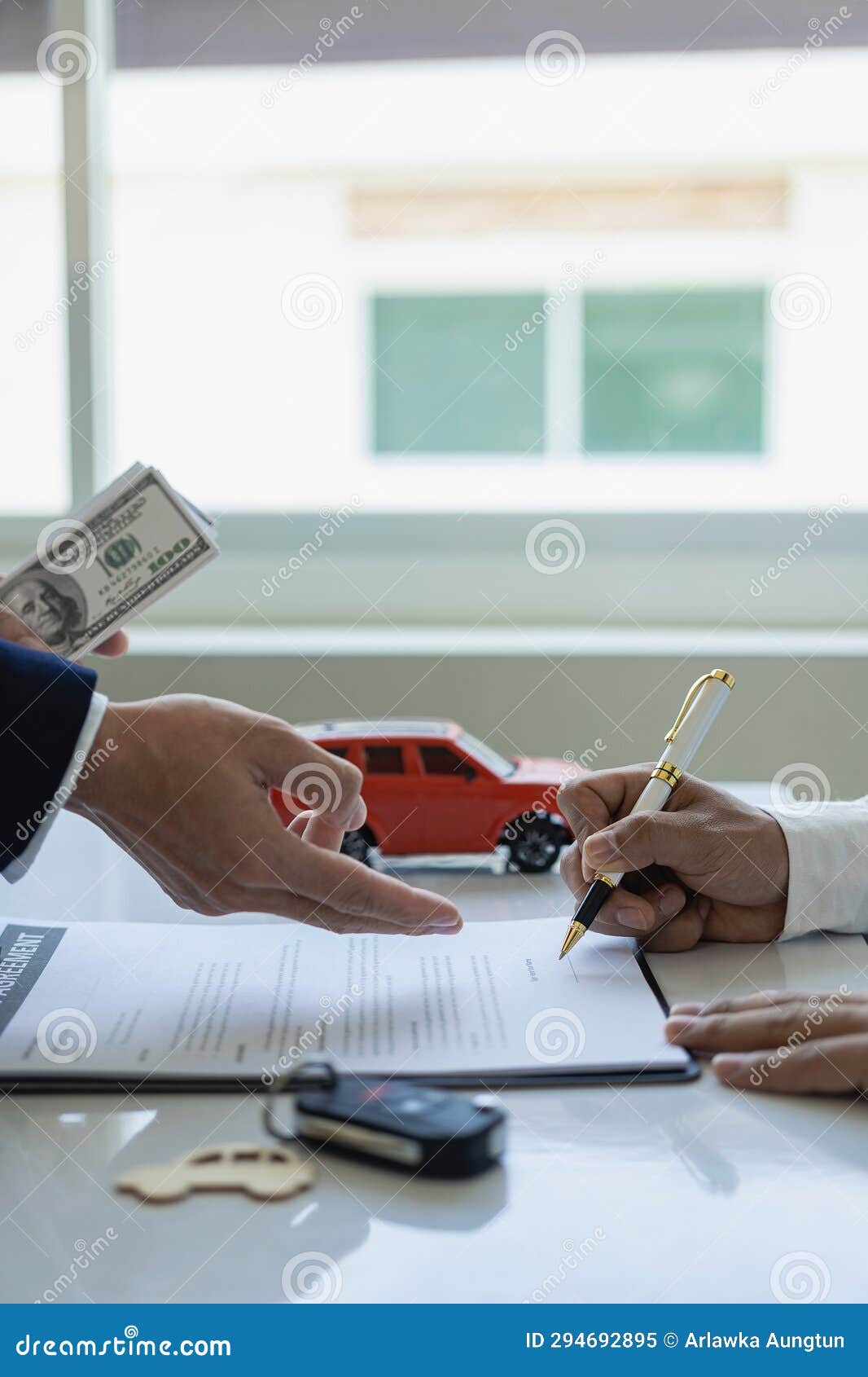 A Friendly Car Salesman is Sitting at a Table with a Customer. and ...