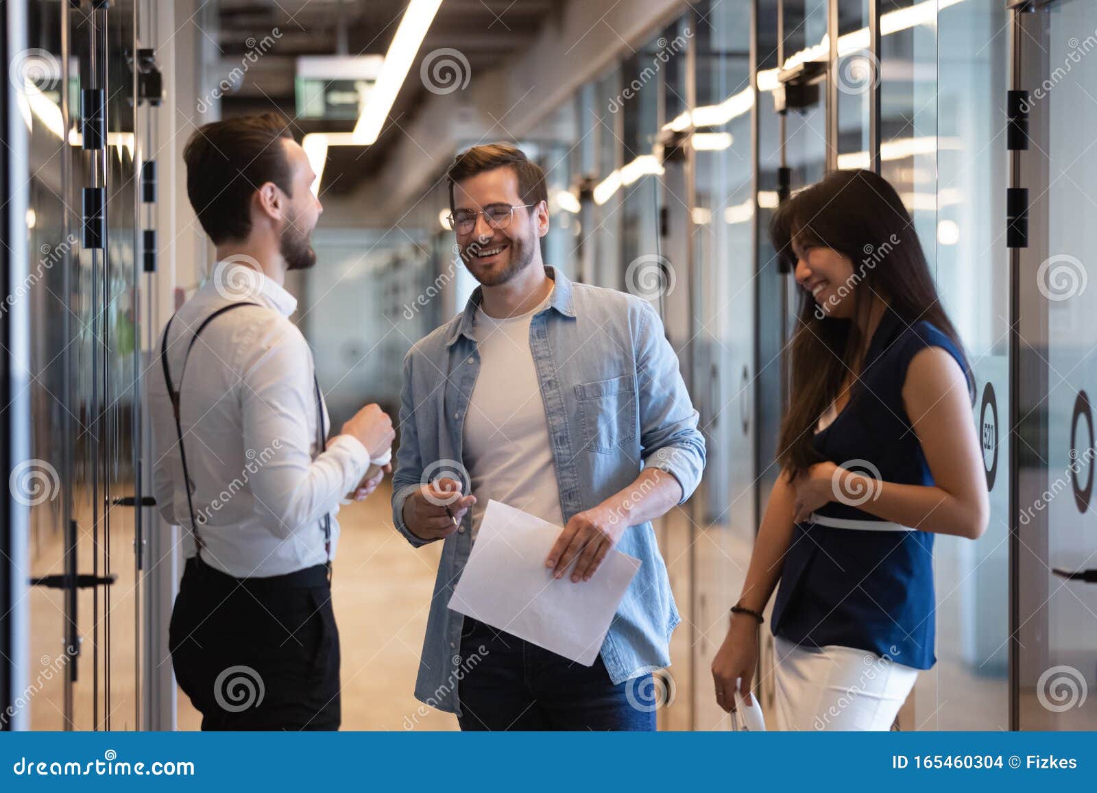 Friendly Diverse Office Workers Standing in Hallway Chatting during ...