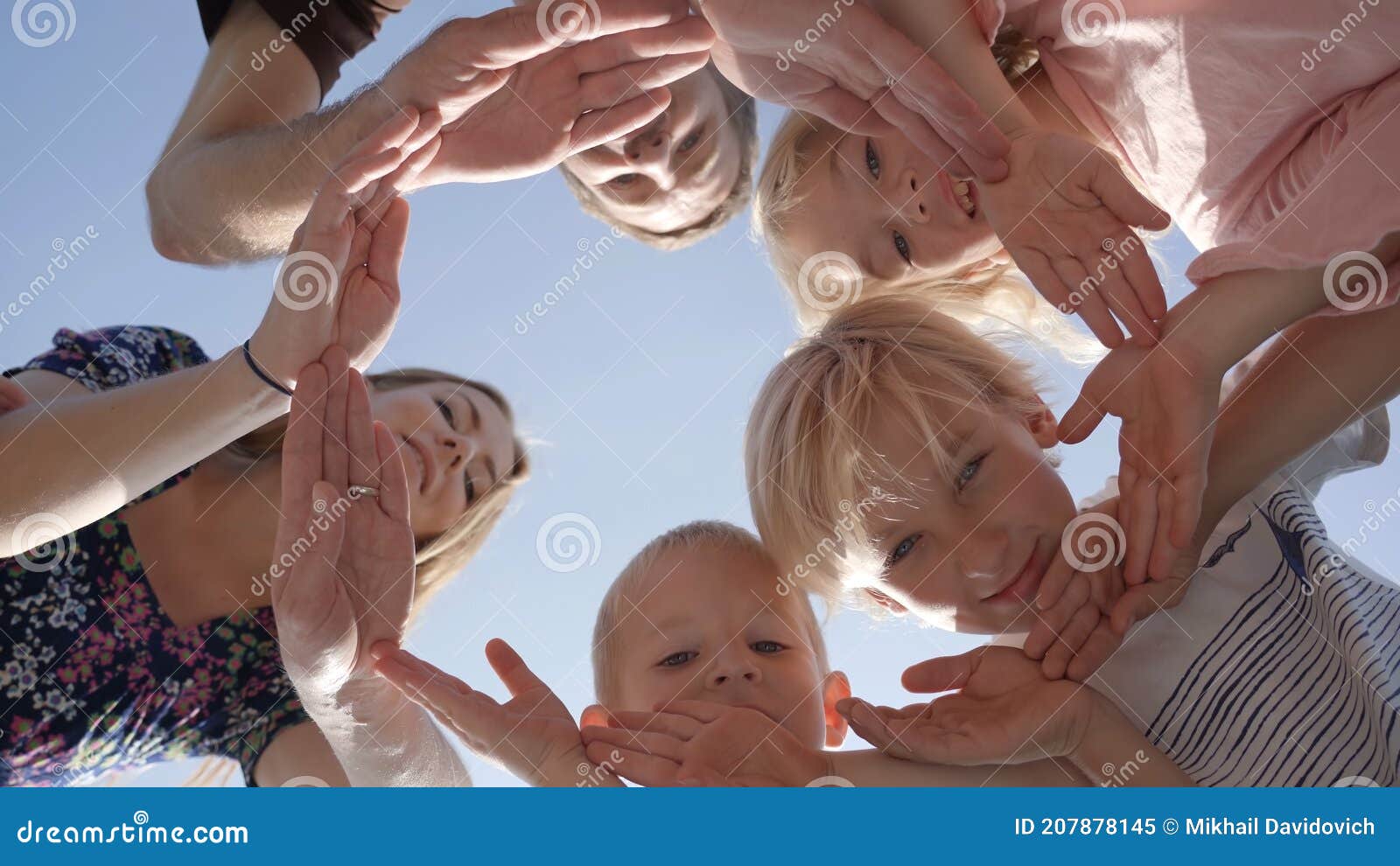 A Friendly Family Makes a Circle Out of Their Hands and Looks into it ...