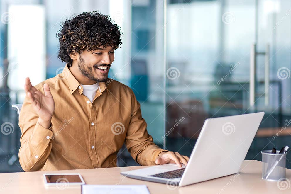 Friendly Middle Eastern Programmer Waving Hand while Using Portable ...