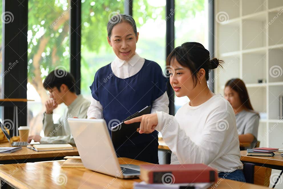 Friendly Senior Professor Helping Female Student with Assignment Stock ...