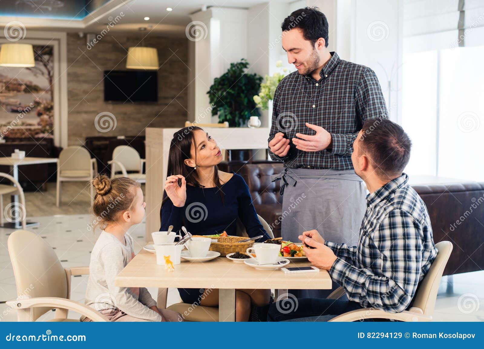 Friendly Smiling Waiter Taking Order at Table of Family Having Dinner ...