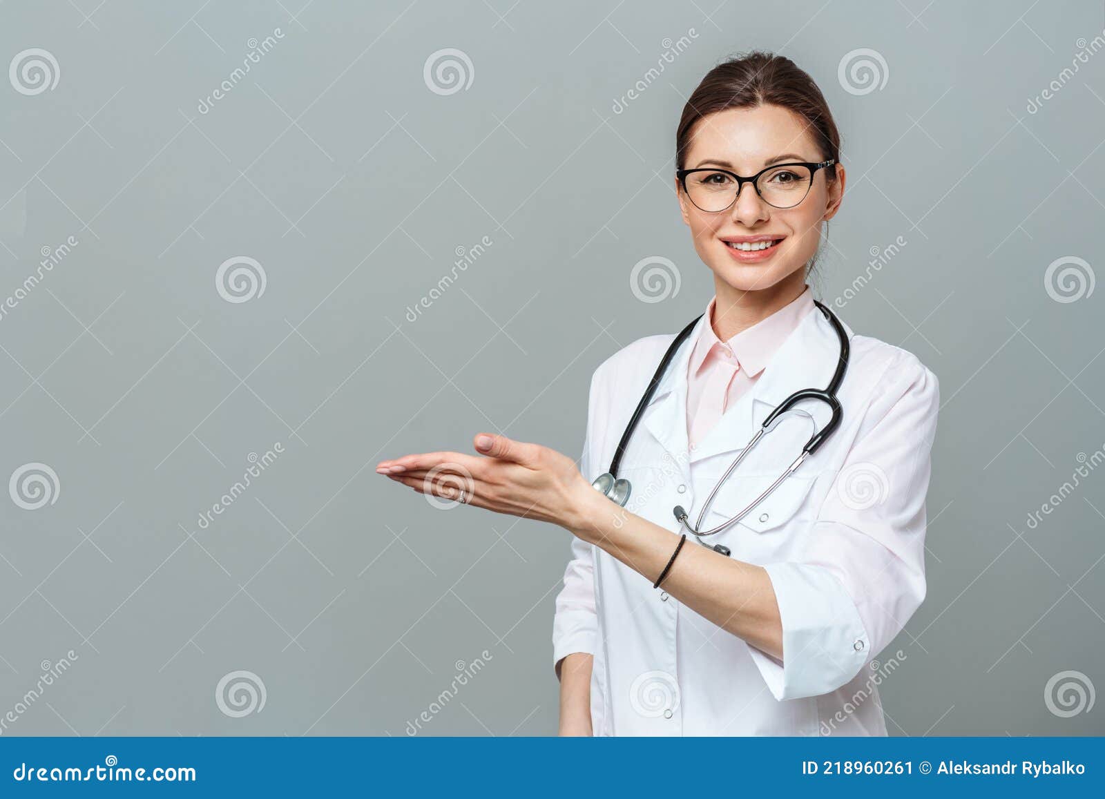 Friendly Smiling Young Female Doctor. Hand Pointing at Copy Space. on a ...
