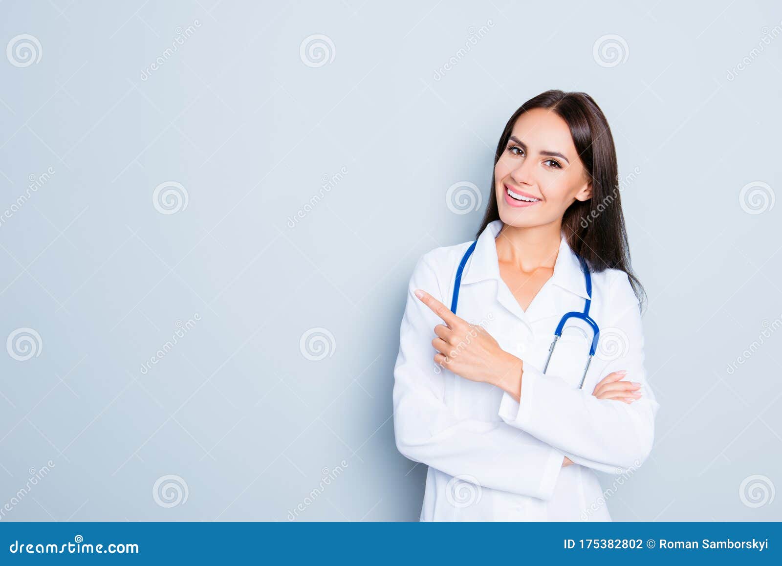 Friendly Smiling Young Female Doctor Pointing with Finger Stock Photo ...