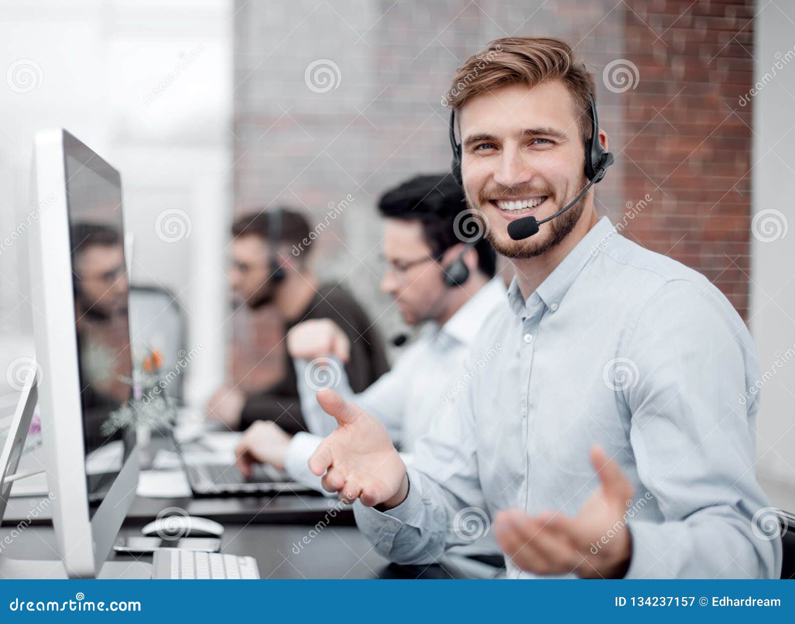 Friendly Staff with a Headset in the Workplace in the Business Center ...