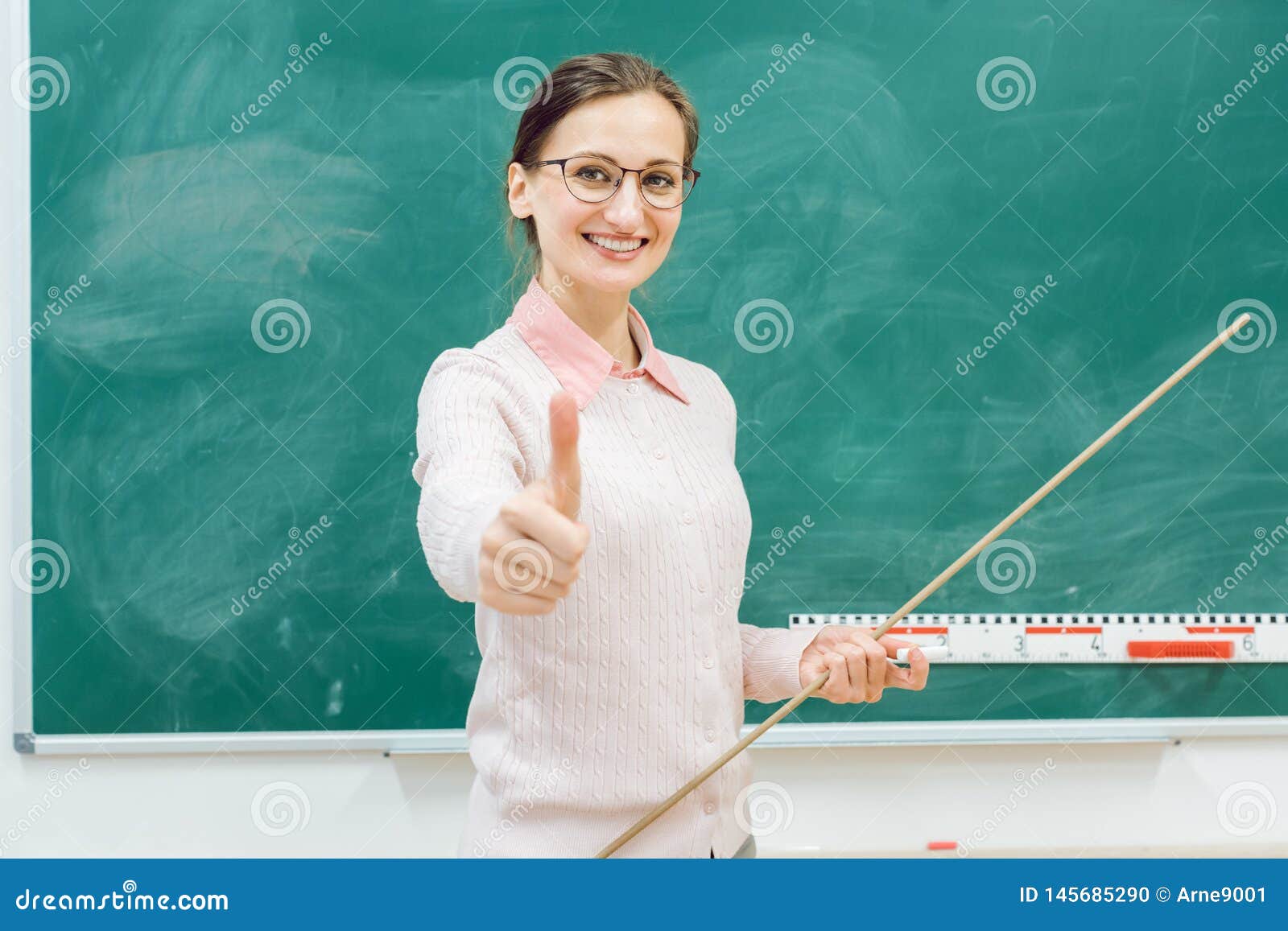 Friendly Teacher Standing in Front of Blackboard in Class Stock Photo ...