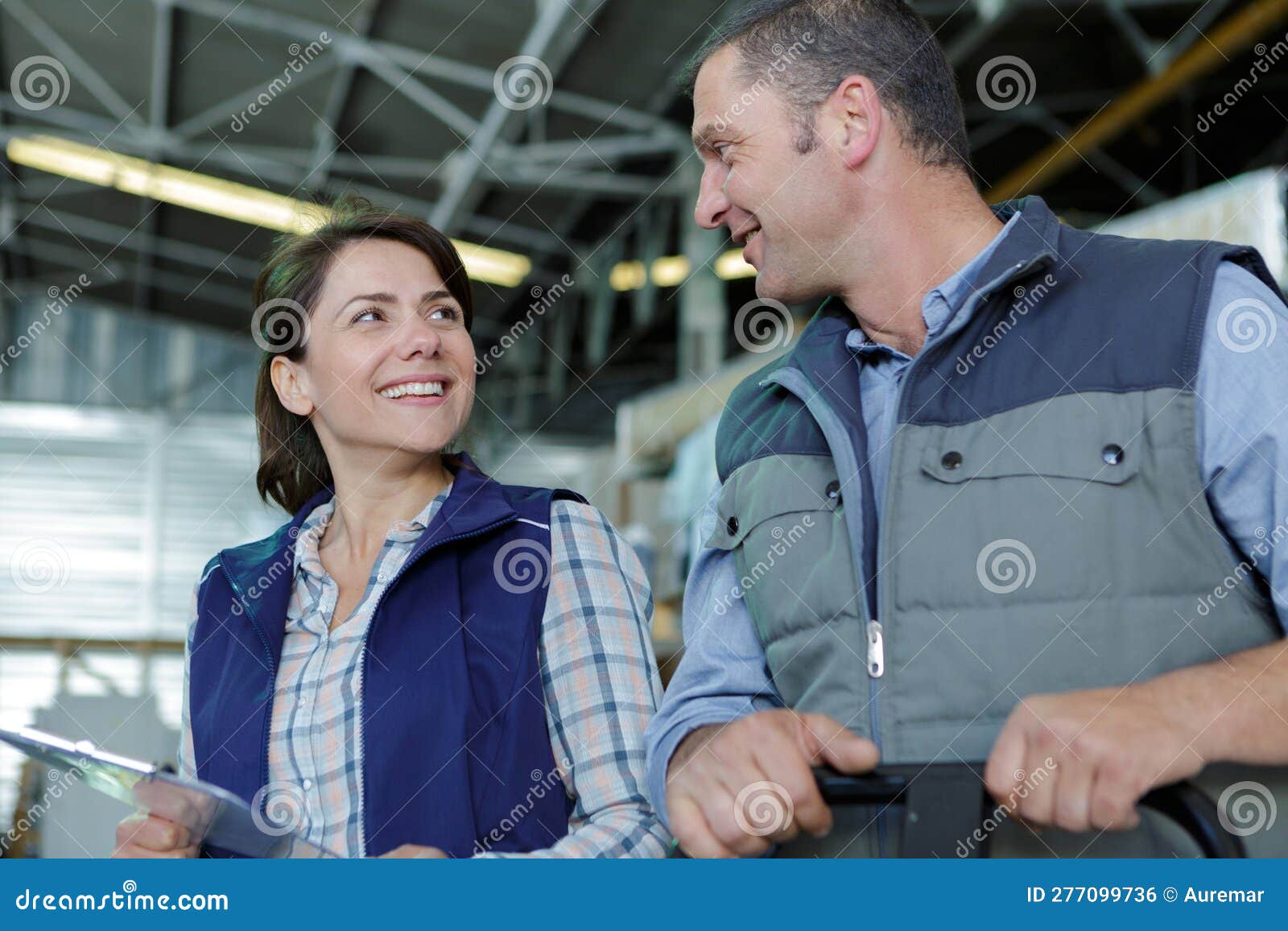 Friendly Warehouse Workers Smiling at Each Other Stock Photo - Image of ...