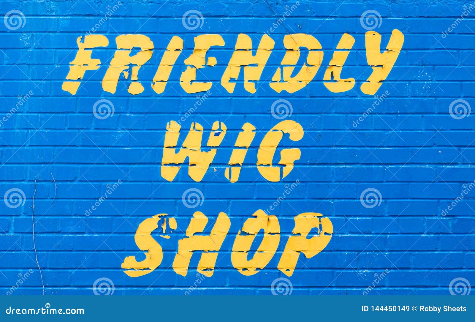 A Friendly Wig Shop Sign on a Wall Stock Image - Image of blue, signage ...