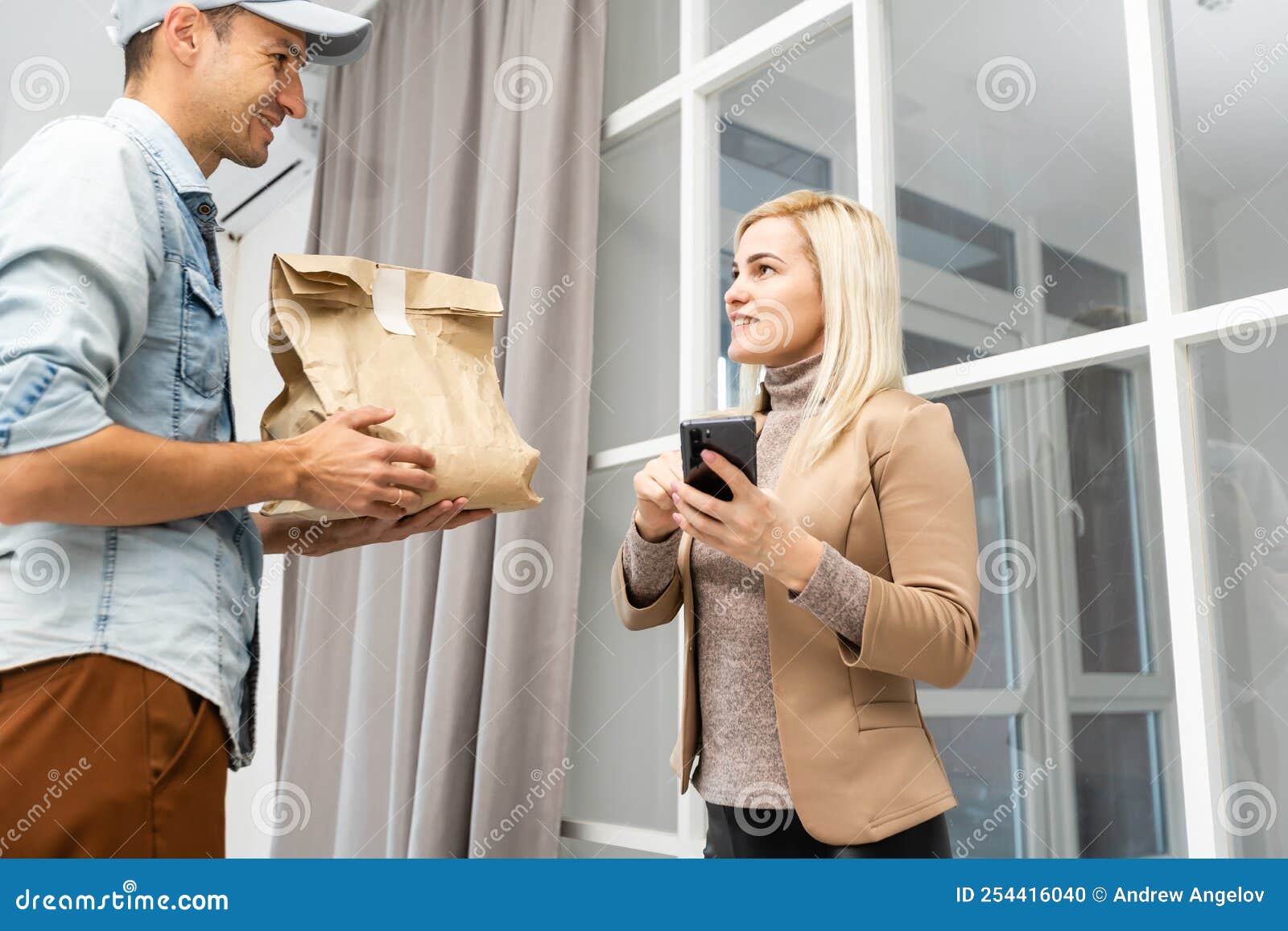 Friendly Young Delivery Man Delivering a Package Stock Photo - Image of ...