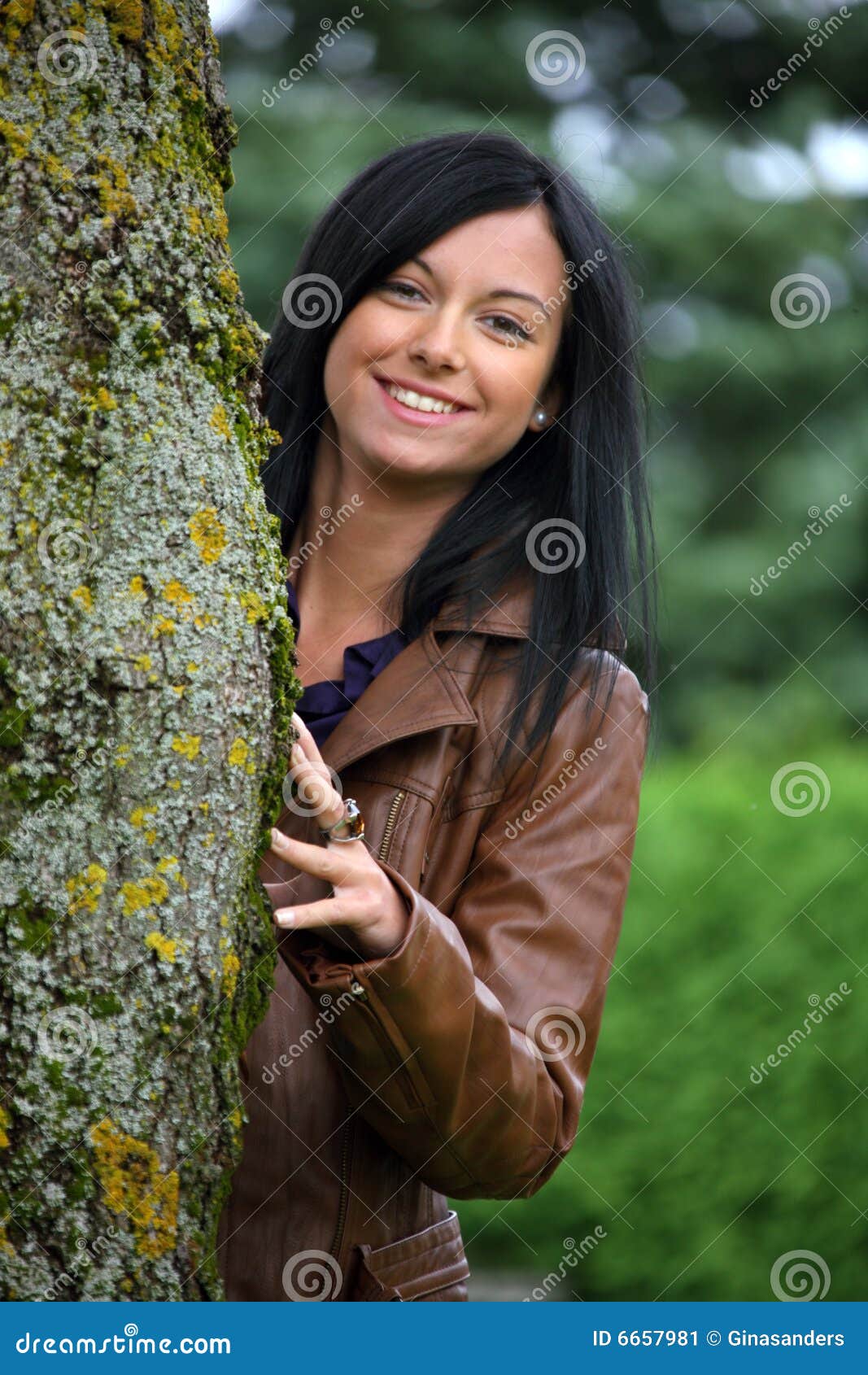 Friendly Young Woman Looks Out from Behind a Tree Stock Image - Image ...
