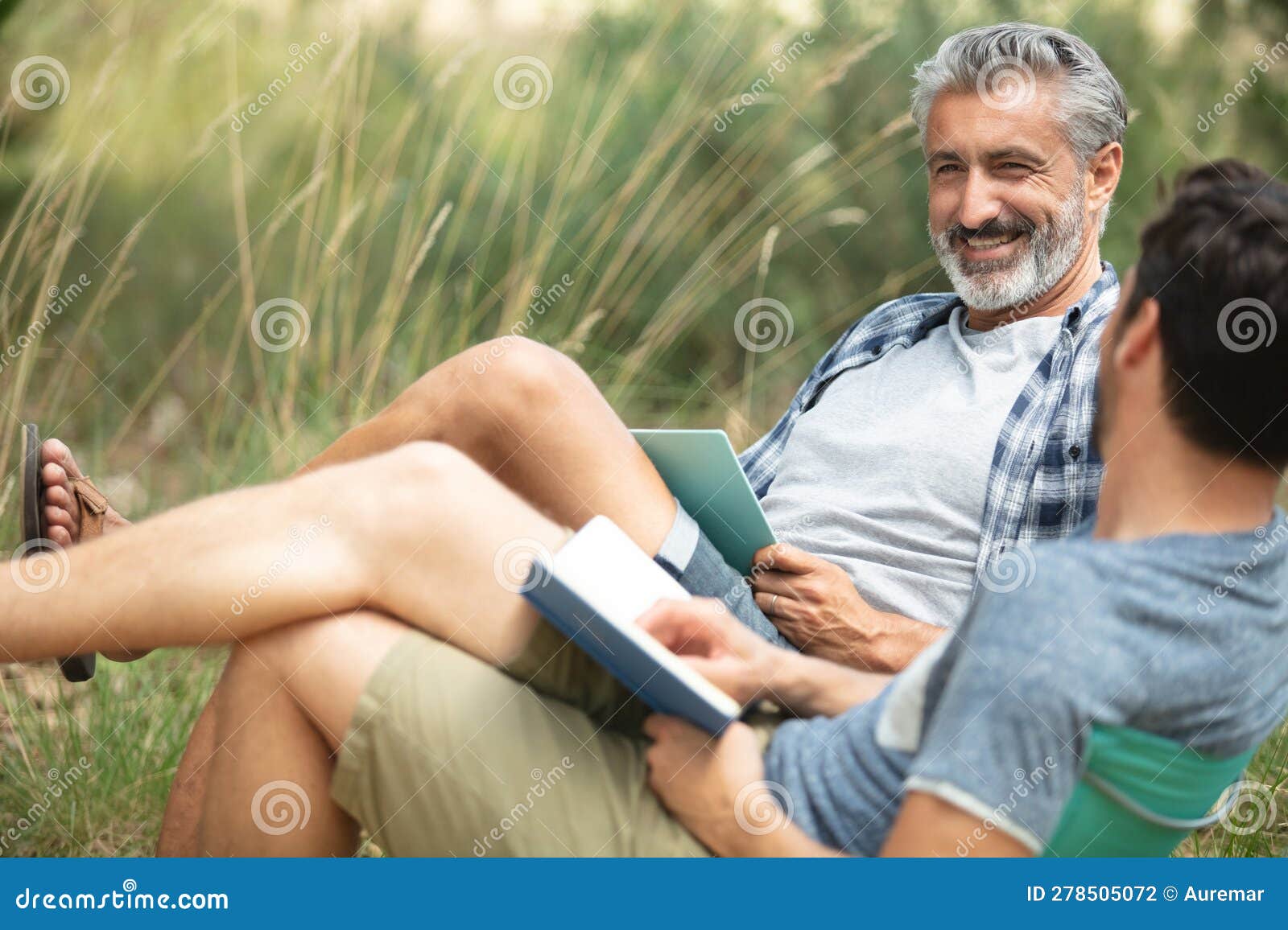 Friends in Campsite Reading Book Stock Photo - Image of cool, nature ...