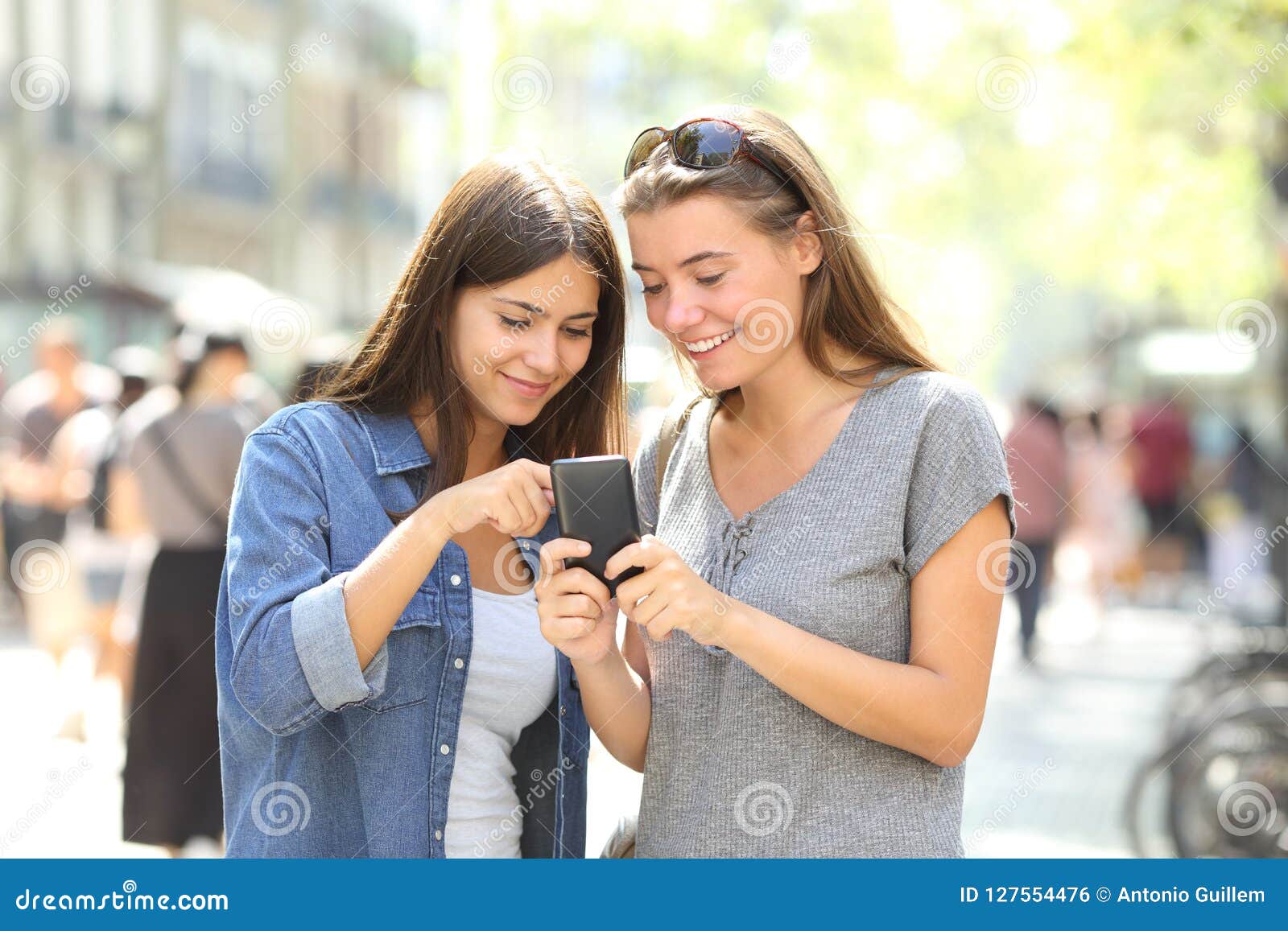 Friends Checking Smart Phone Content in the Street Stock Photo - Image ...