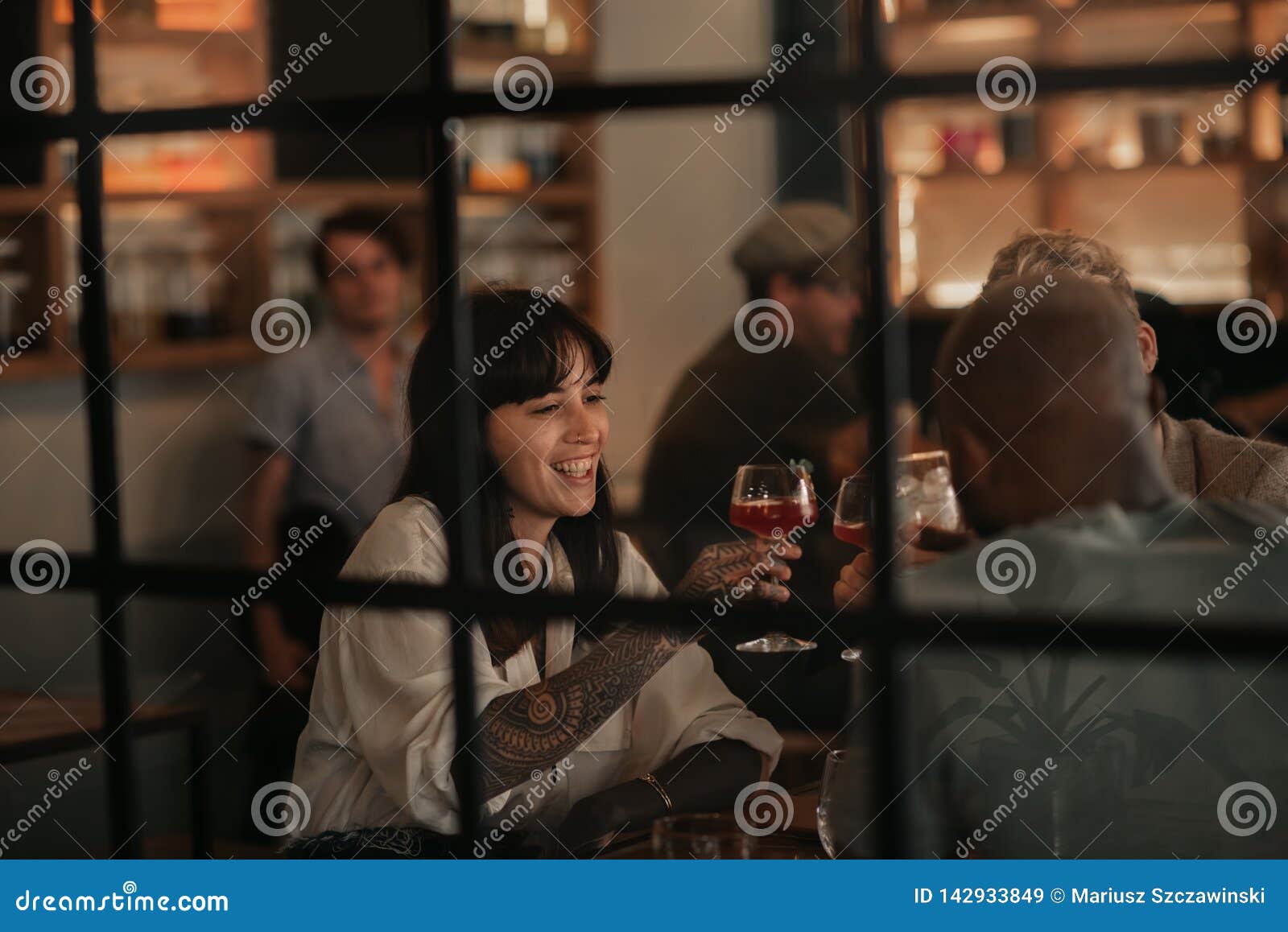 Friends Cheering with Drinks at Bar Table in the Evening Stock Image ...