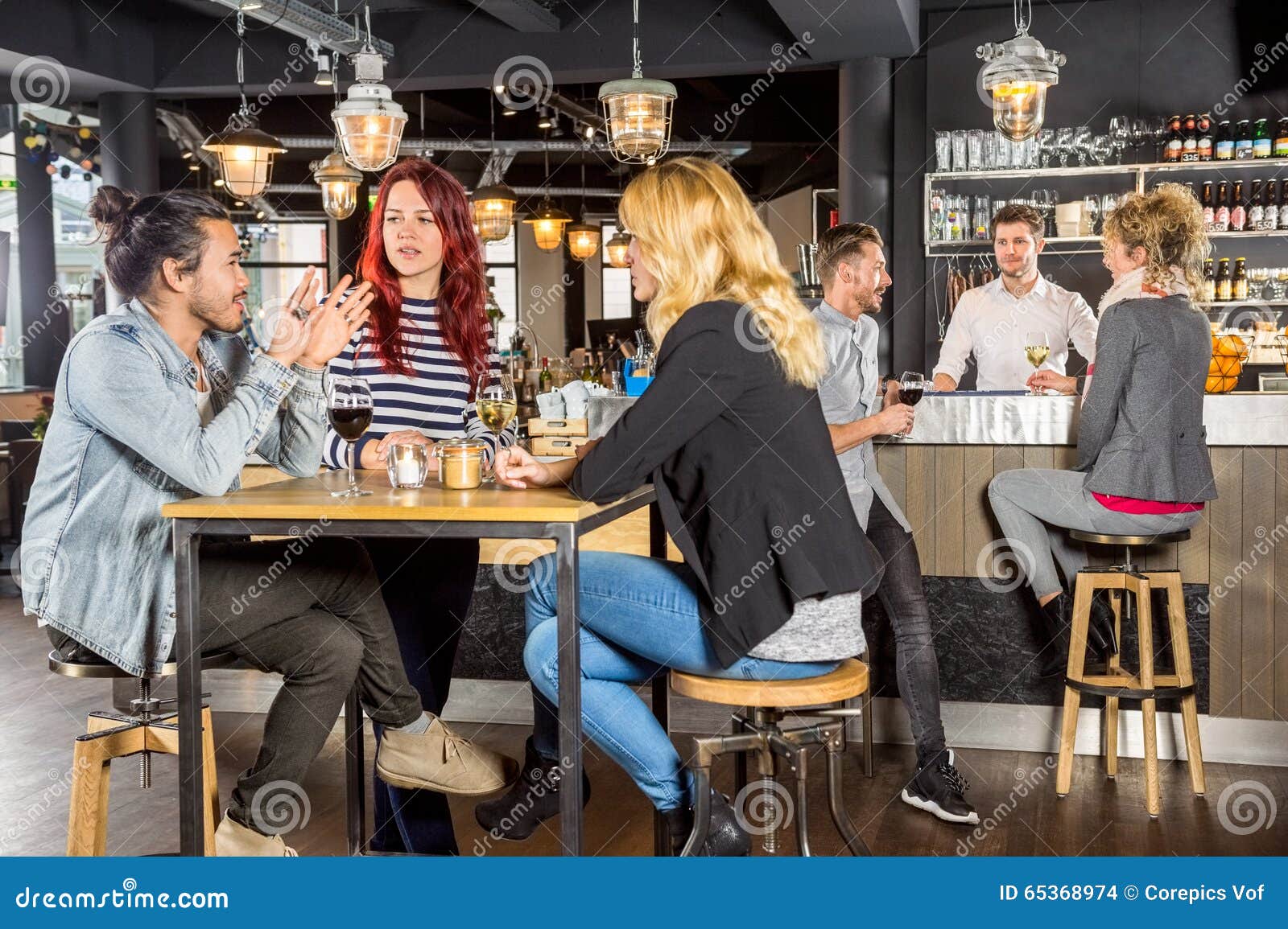 Friends Conversing while Sitting at Table in Bar Stock Photo - Image of ...