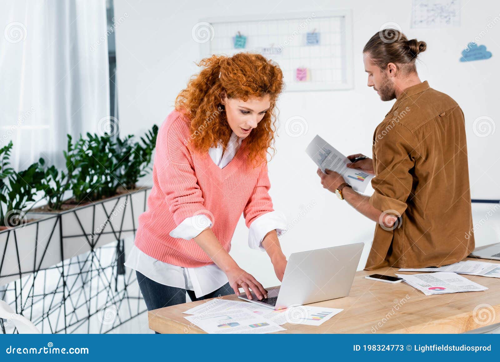Friends Doing Paperwork and Using Laptop in Office Stock Image - Image ...