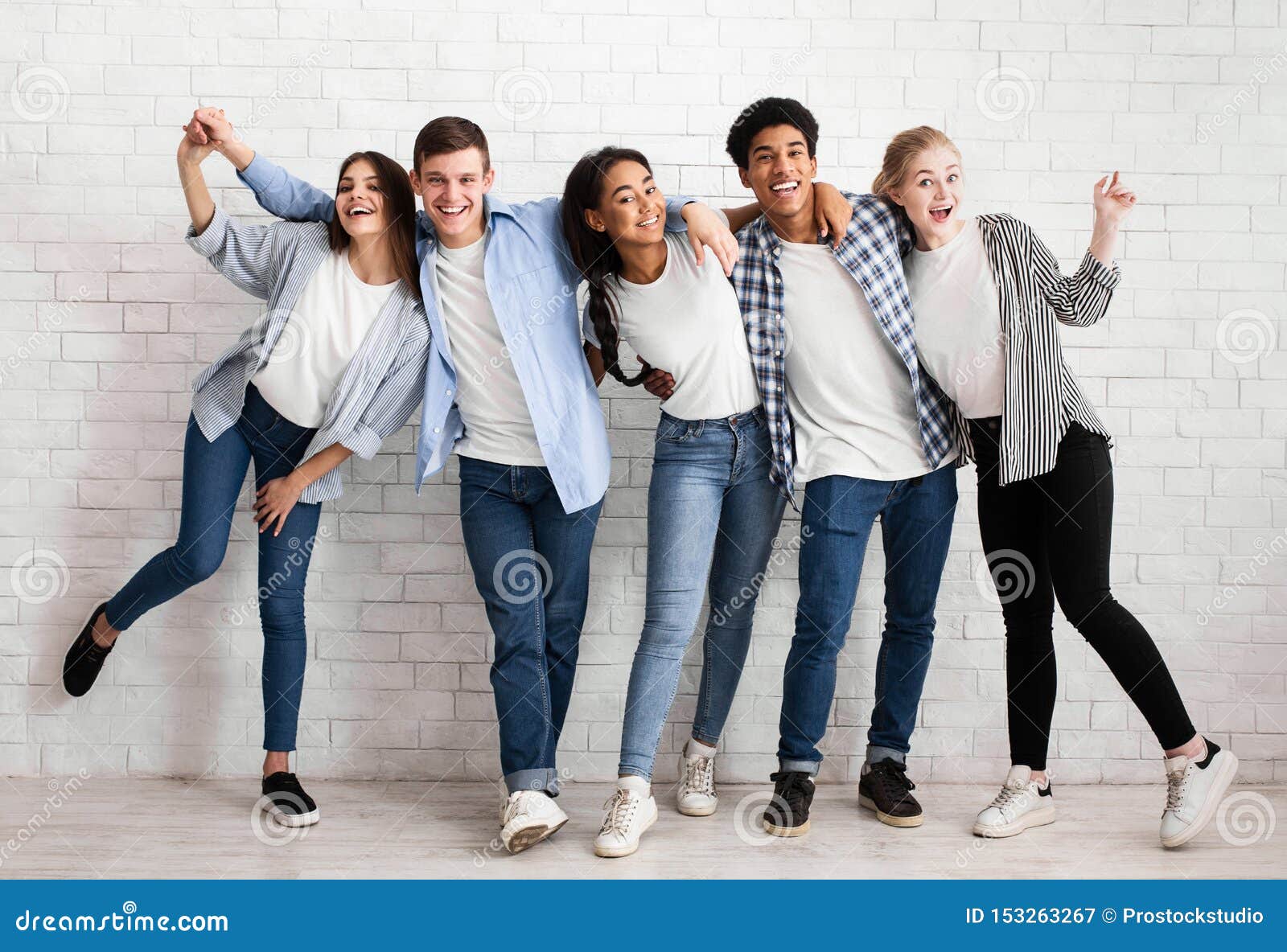 Friends Embracing and Having Fun Over White Brick Wall Stock Image ...