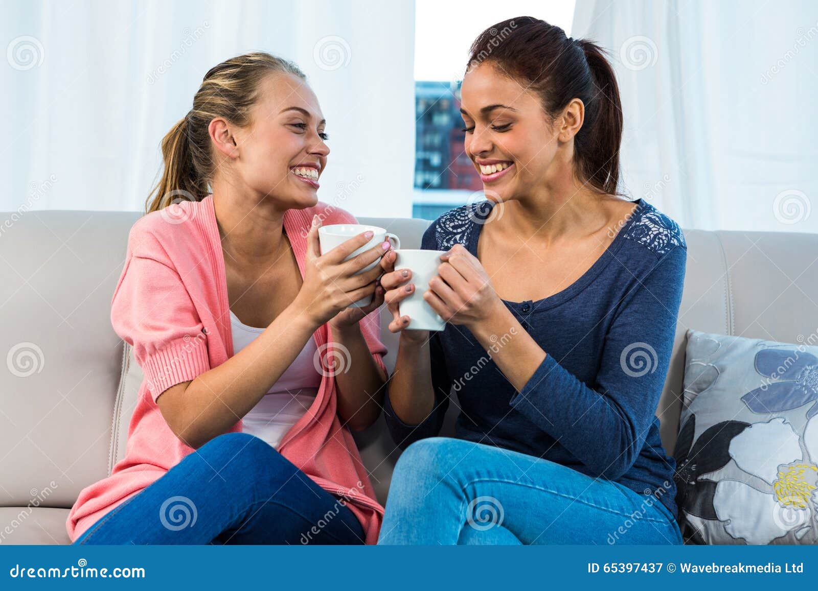 Friends having tea on sofa stock image. Image of beverage - 65397437