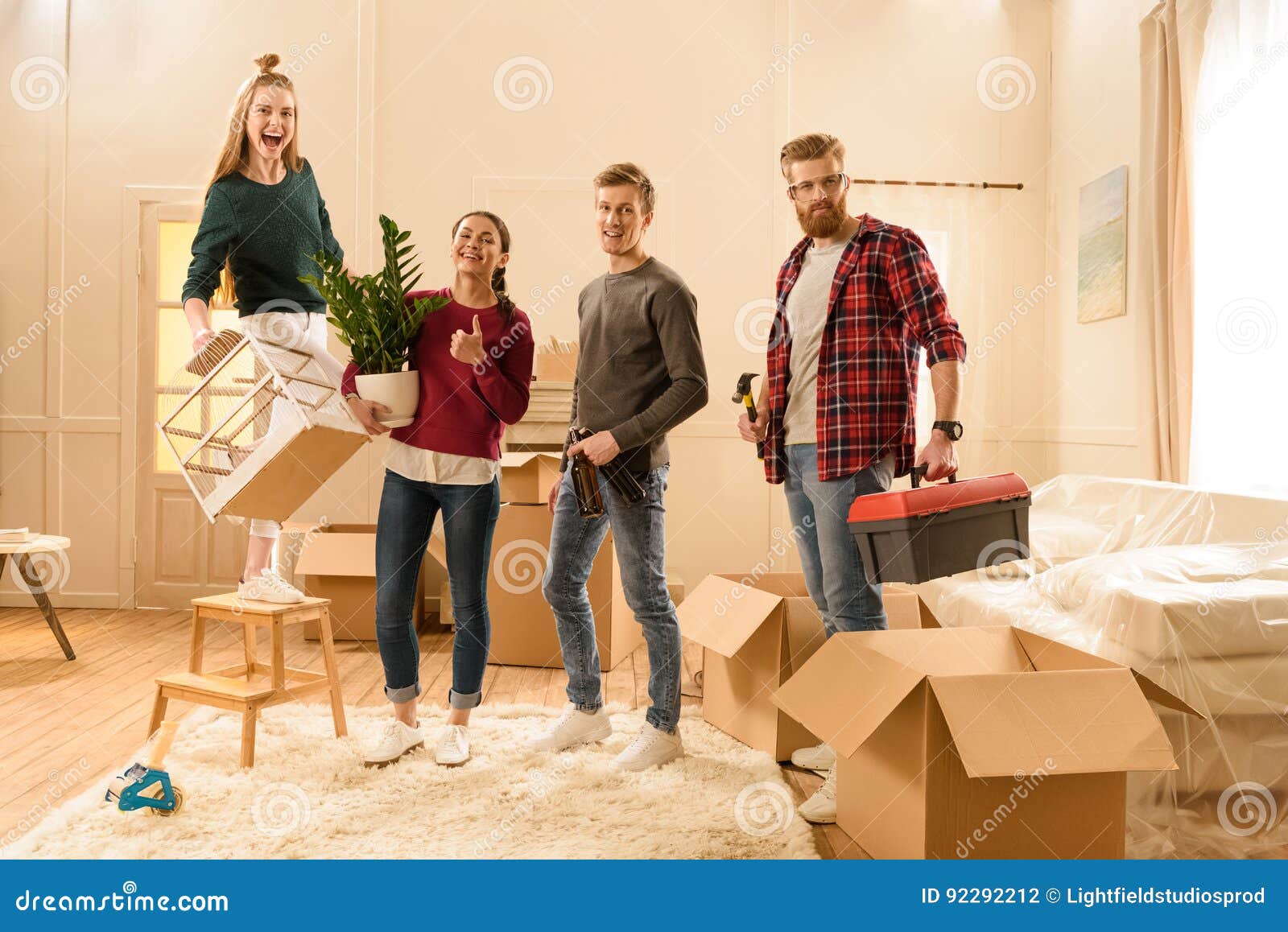 Friends Holding Different Things for Moving into New House Stock Photo ...