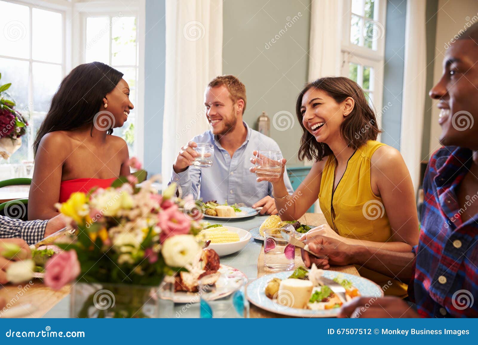 Friends at Home Sitting Around Table for Dinner Party Stock Photo ...