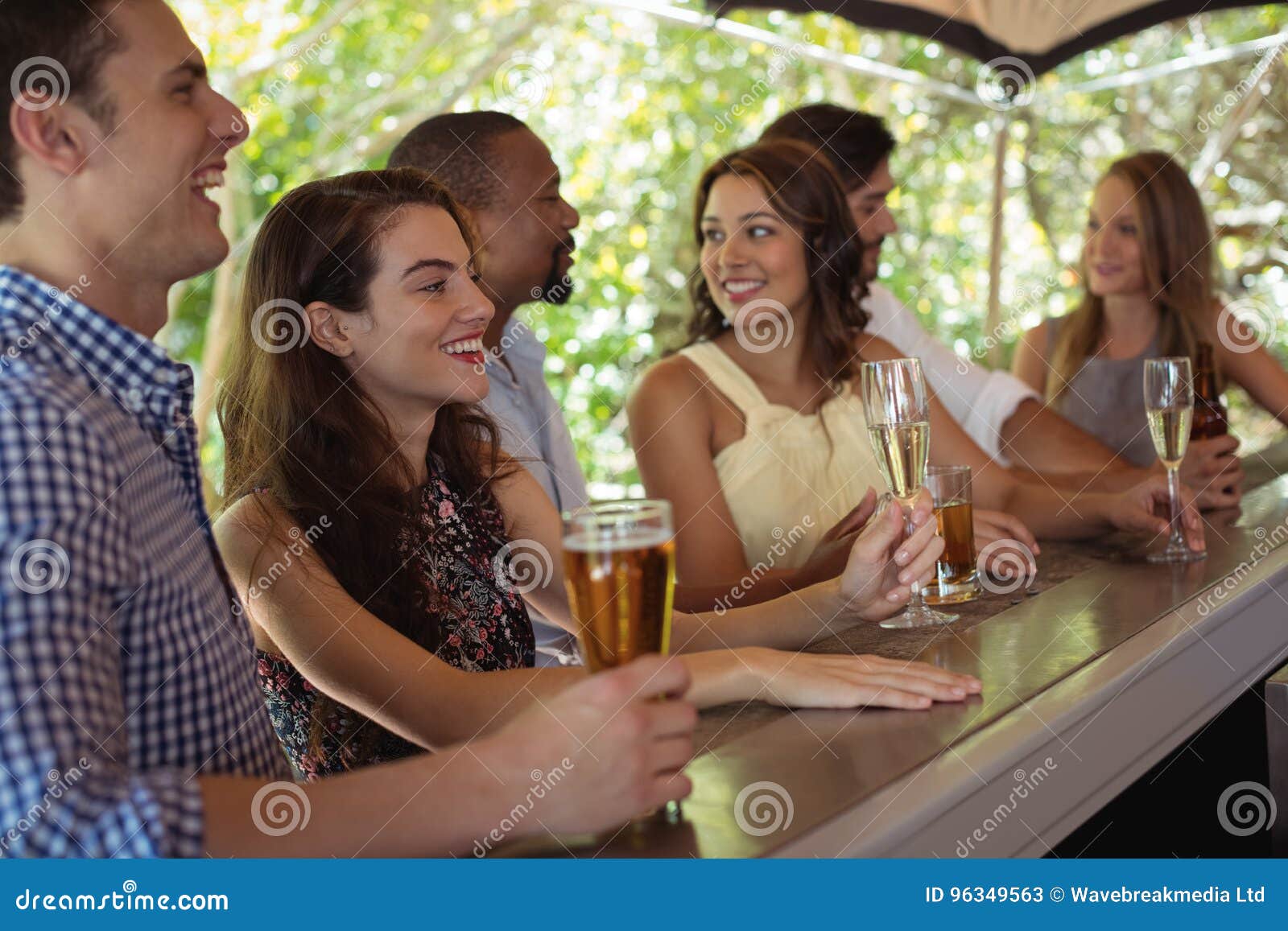 Friends Interacting while Having a Alcohol at Counter Stock Image ...
