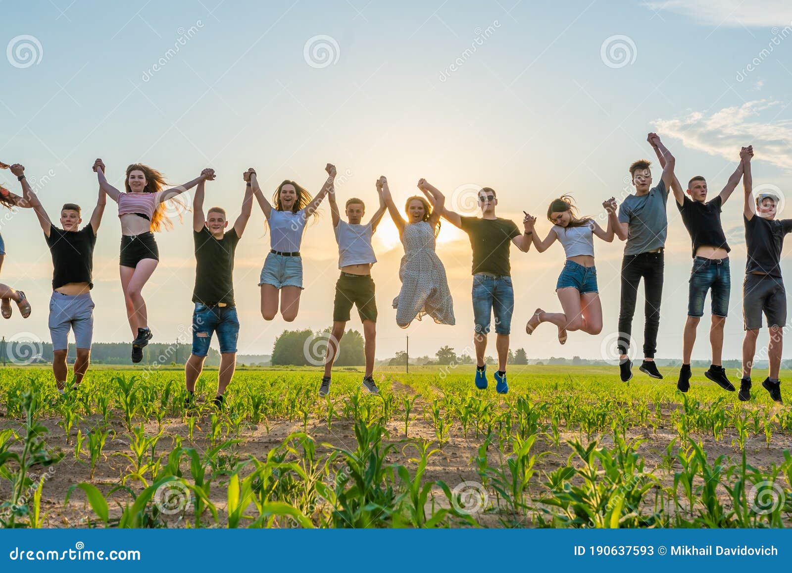 Friends are Jumping Holding Hands at Sunset. Stock Image - Image of ...