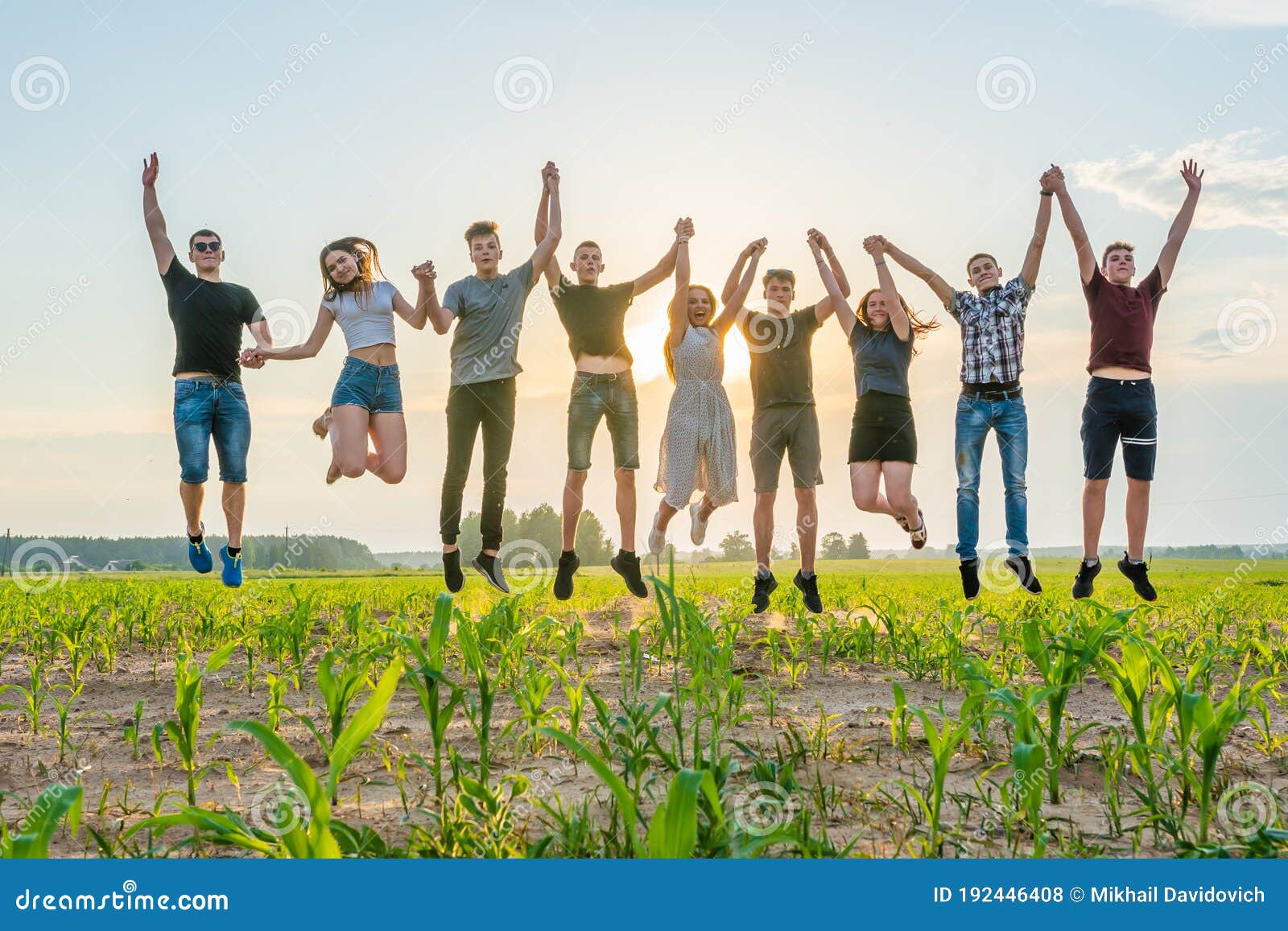 Friends are Jumping Holding Hands at Sunset. Stock Photo - Image of ...